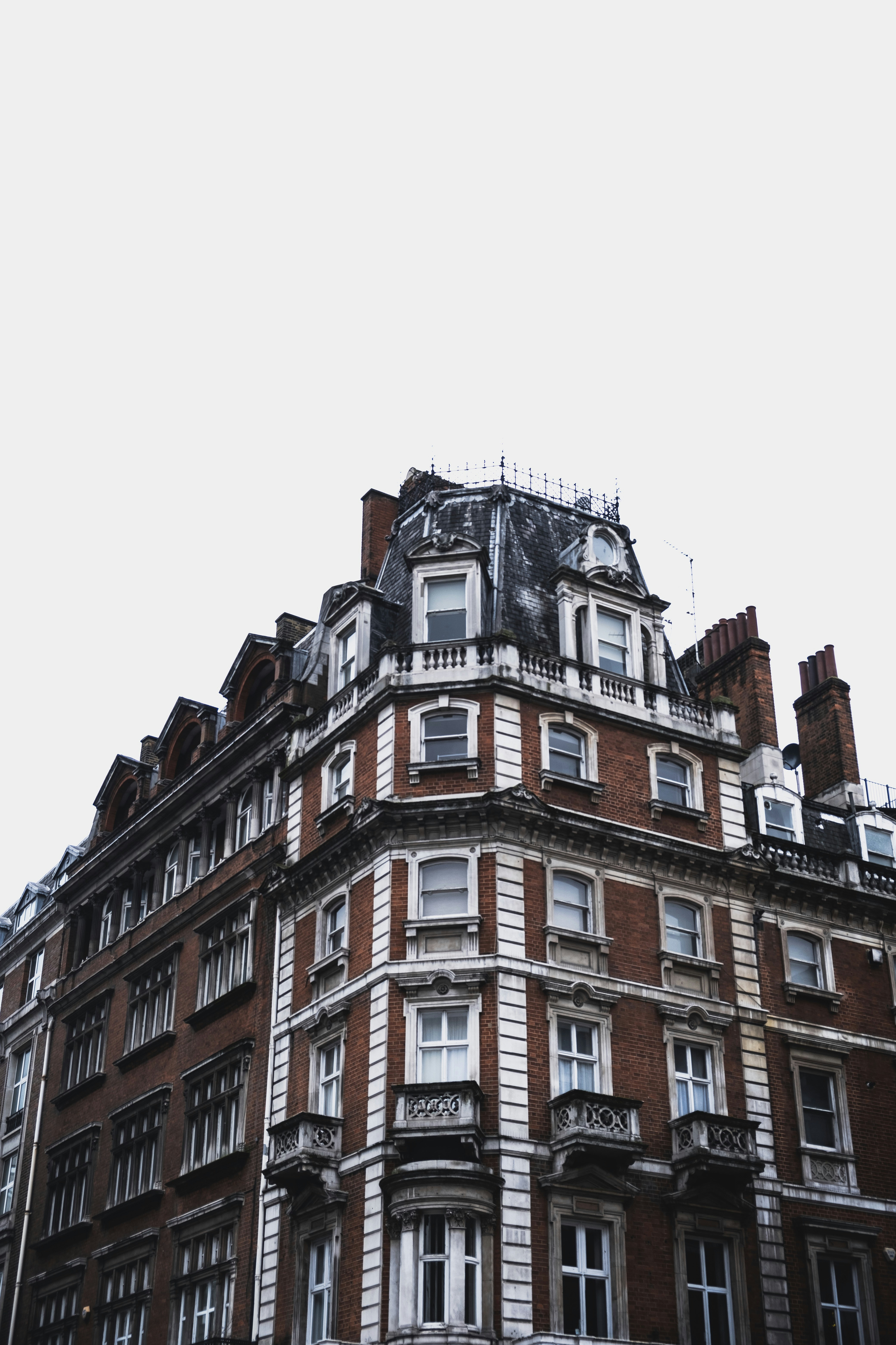 Maroon and white concrete mid-rise building under white sky photo ...