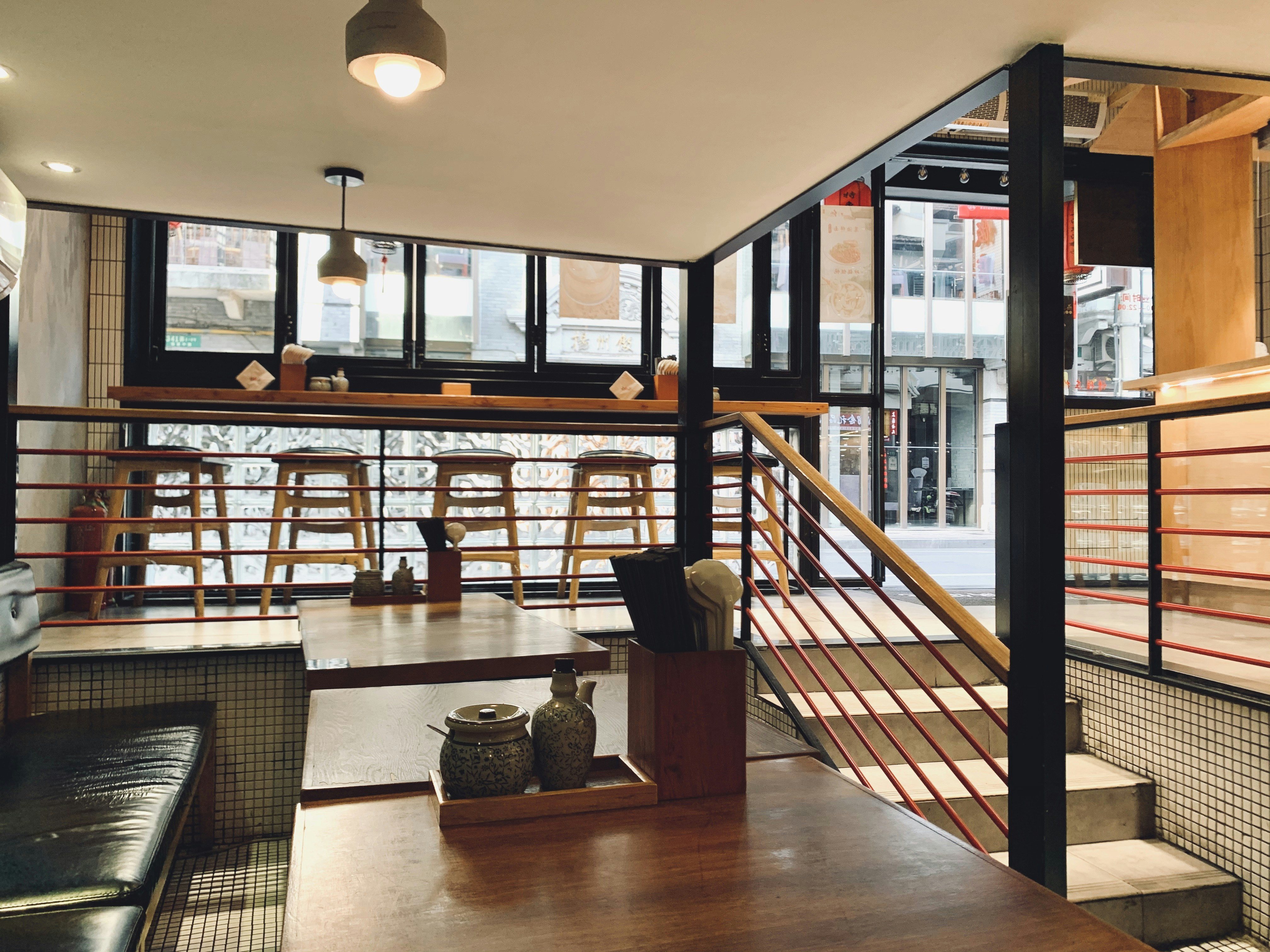 Chic café interior featuring wooden furniture, minimalist decor, and large windows inviting natural light.
