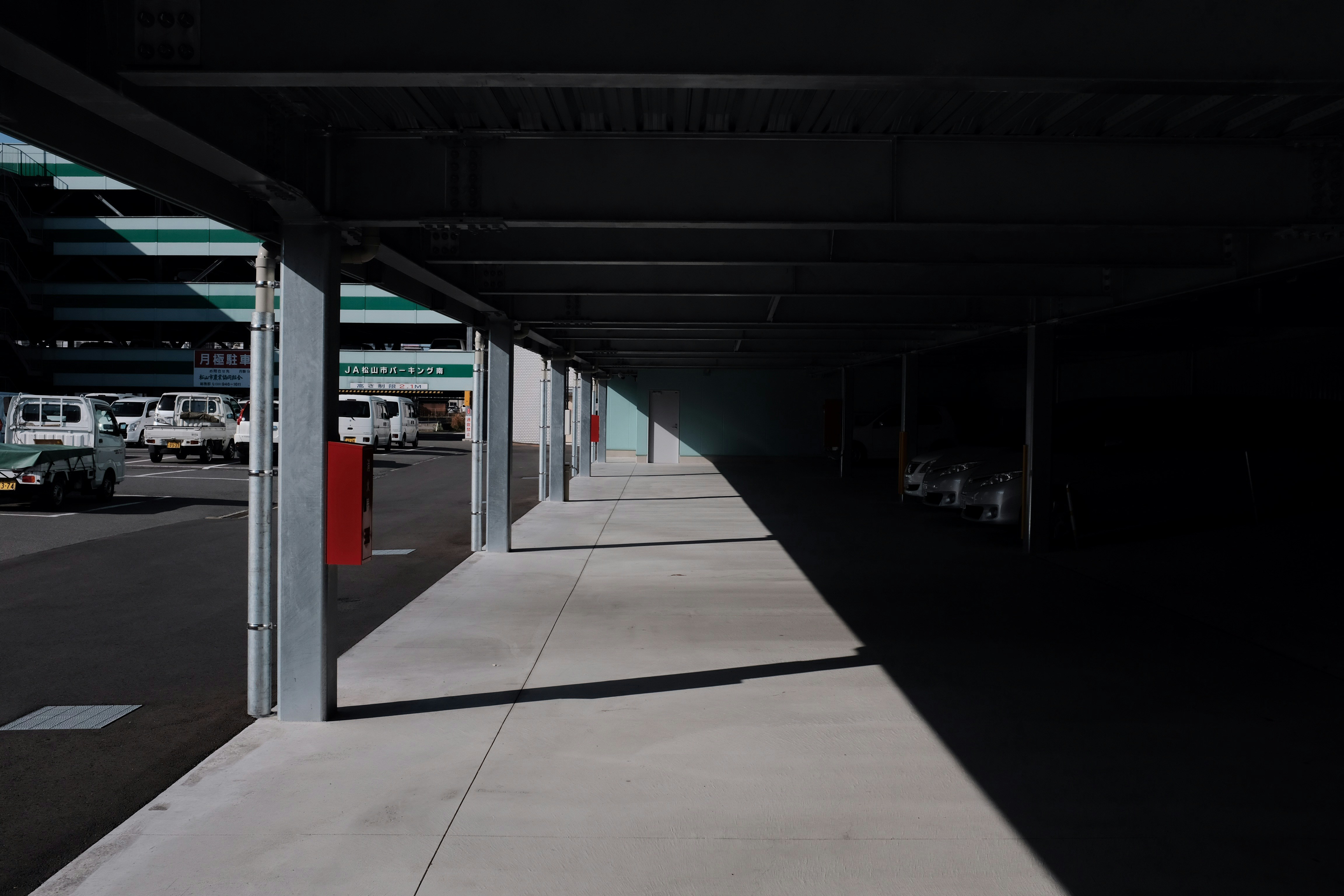 An empty parking structure with stark shadows and geometric lines, showcasing the interplay of light and architecture.