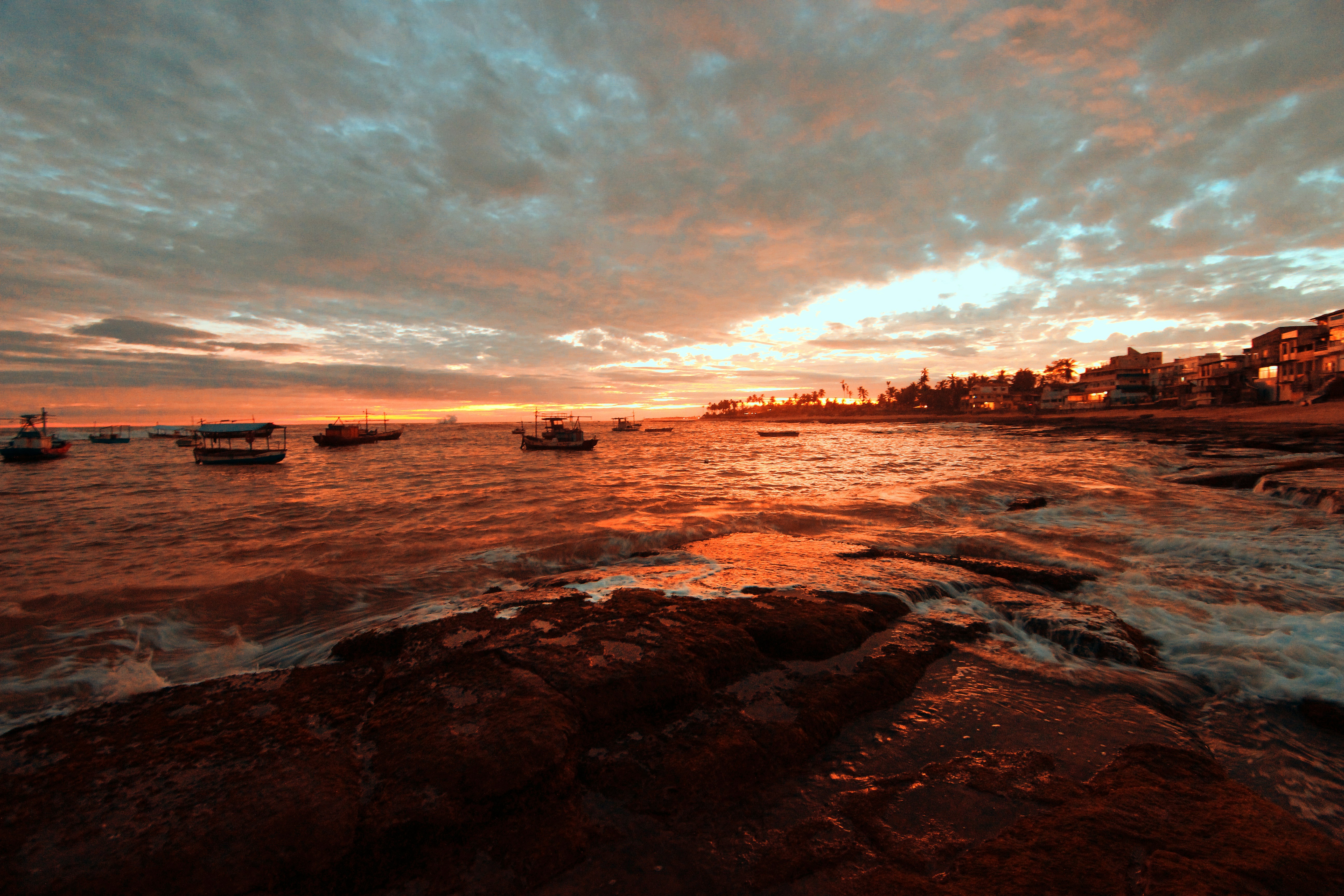 Duskfire Horizon: Boats Quietly Rest Along a Rocky Shore