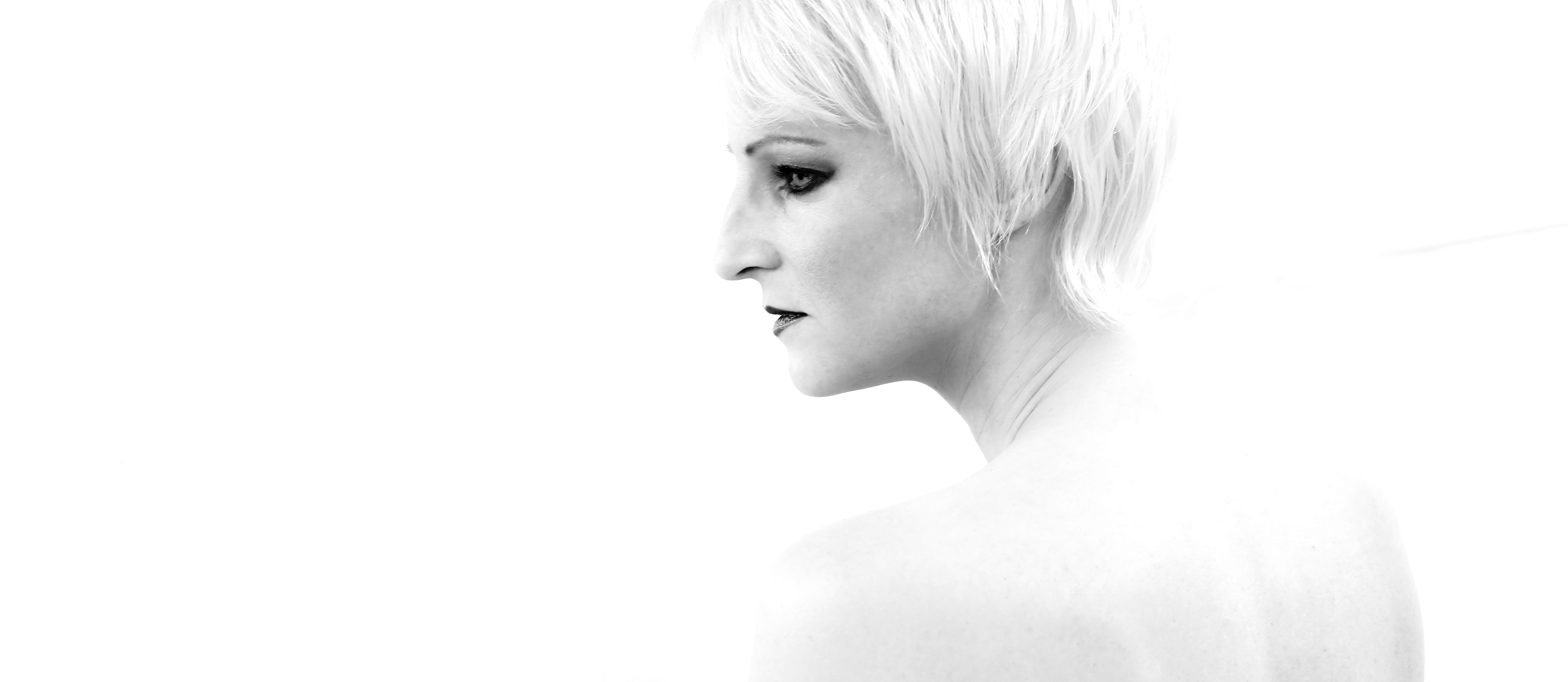 Minimalist portrait of a pale-skinned woman with platinum short hair