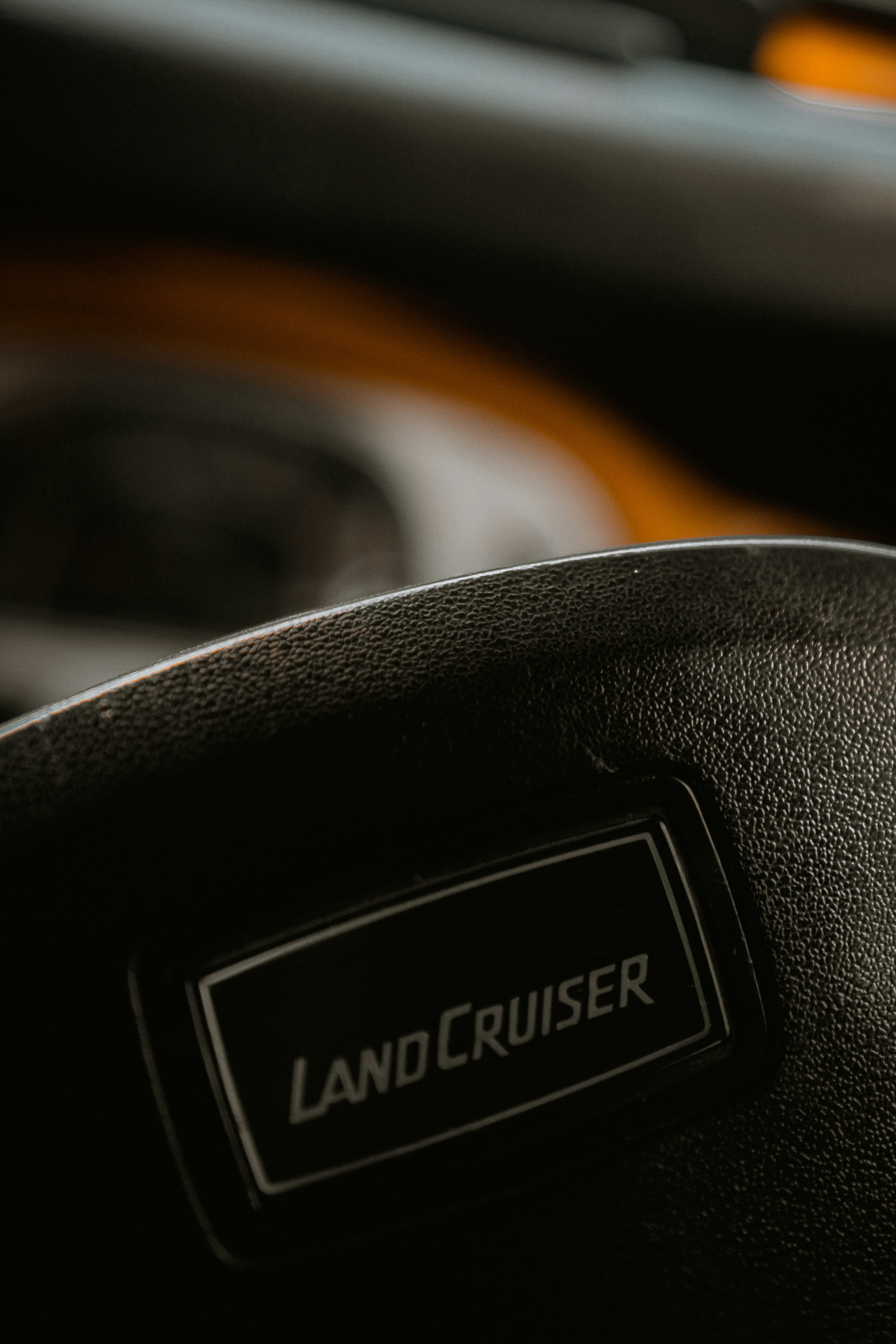 Emblem in Focus: Close-Up on a Land Cruiser Steering Wheel
