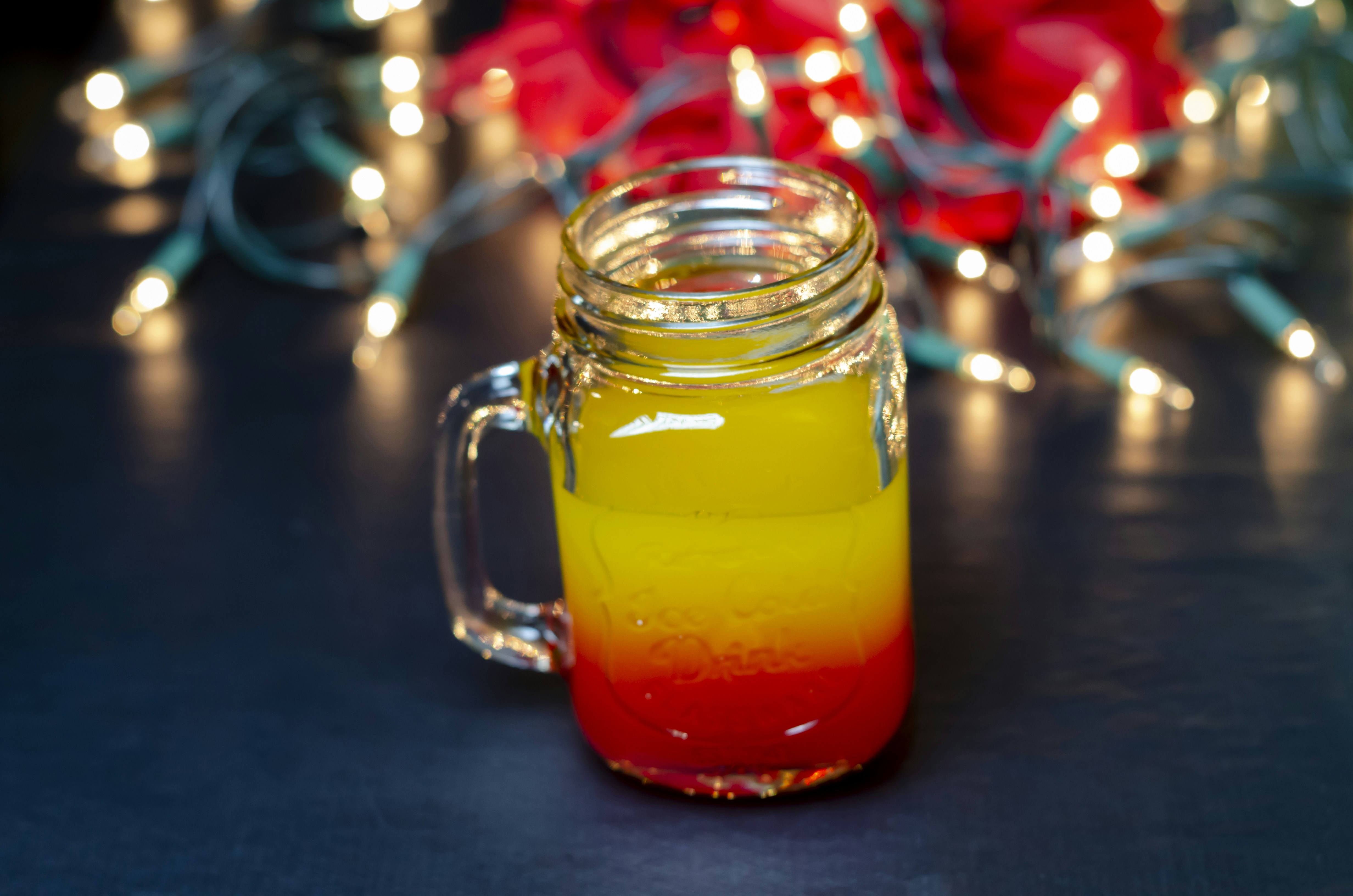 Sunset in a Jar: A Neon-Lit Layered Drink on a Velvet Table