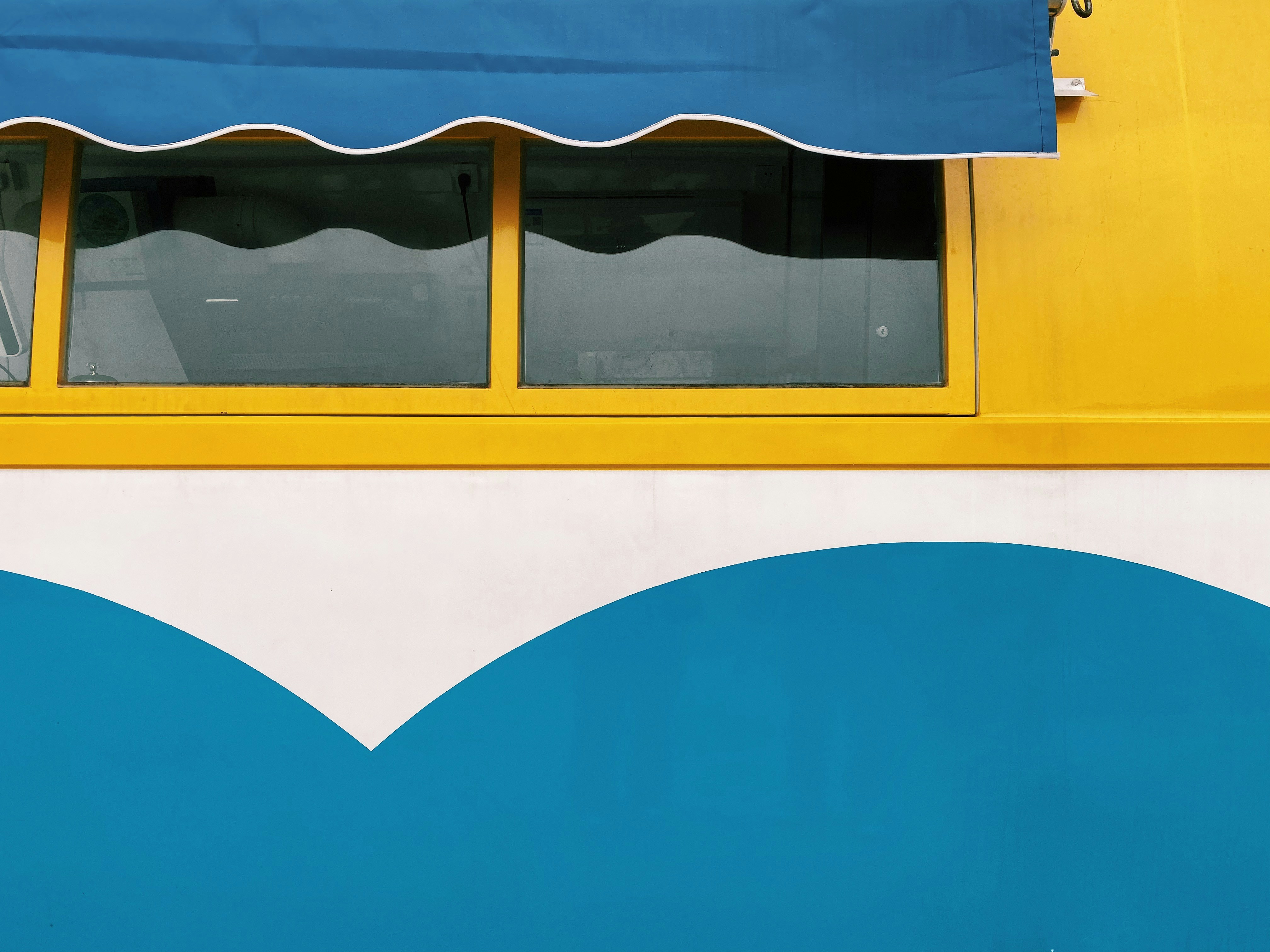Colorful storefront with a blue awning and wavy blue design against a yellow background.