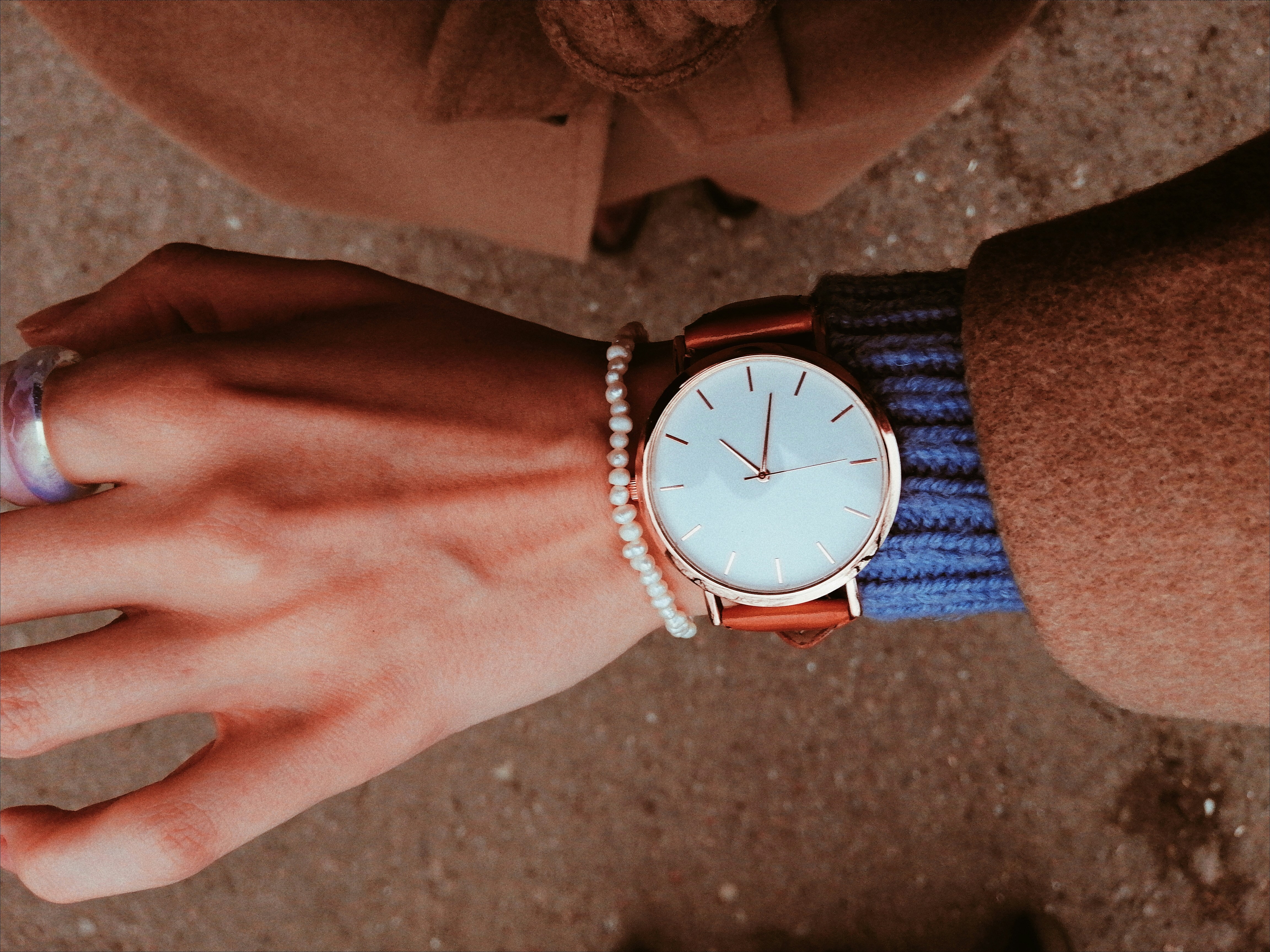 A close-up of a wrist adorned with a stylish watch and a delicate bracelet, showcasing a blend of modern design and personal flair.