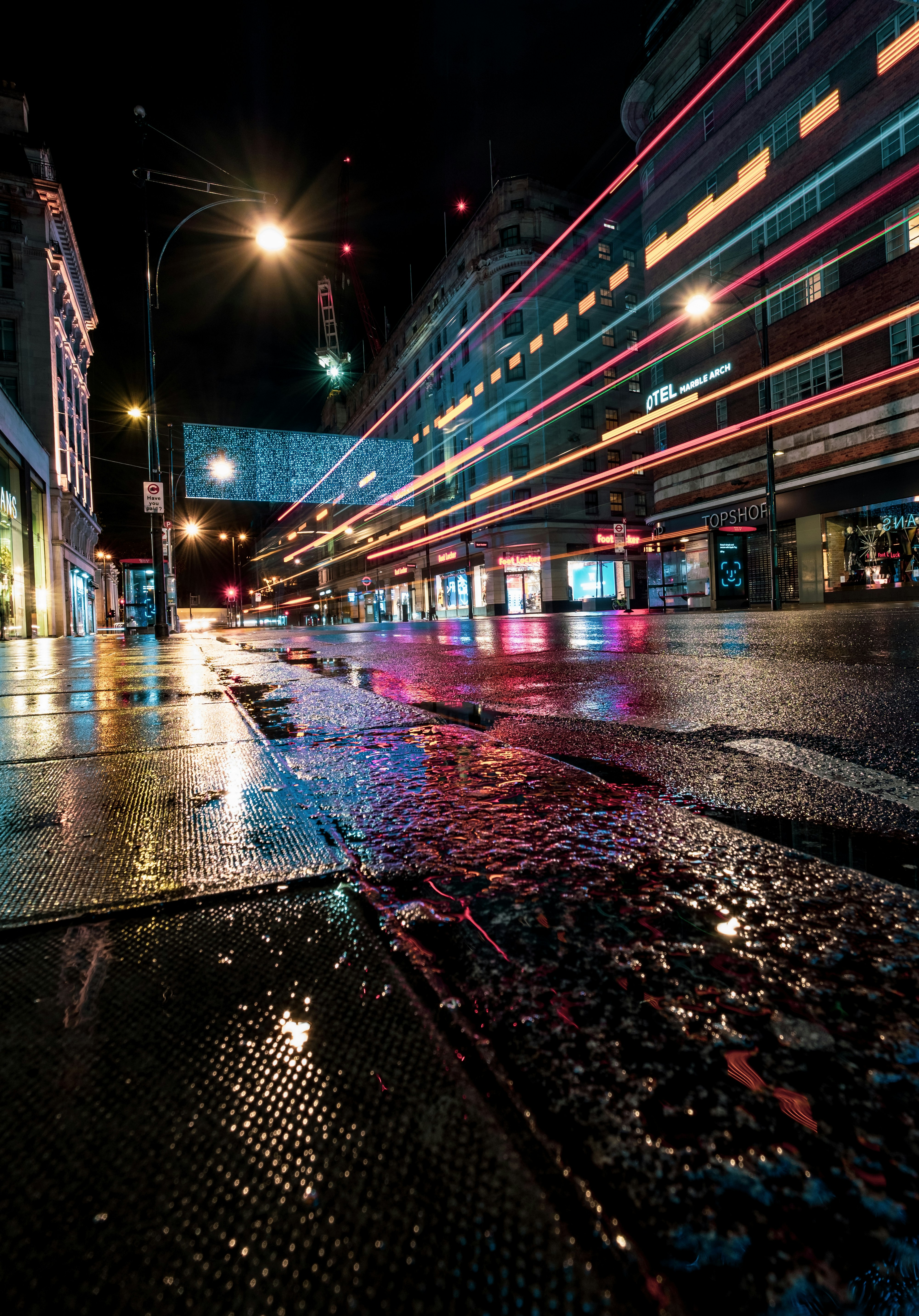 Una calle húmeda de la ciudad por la noche con edificios iluminados ...