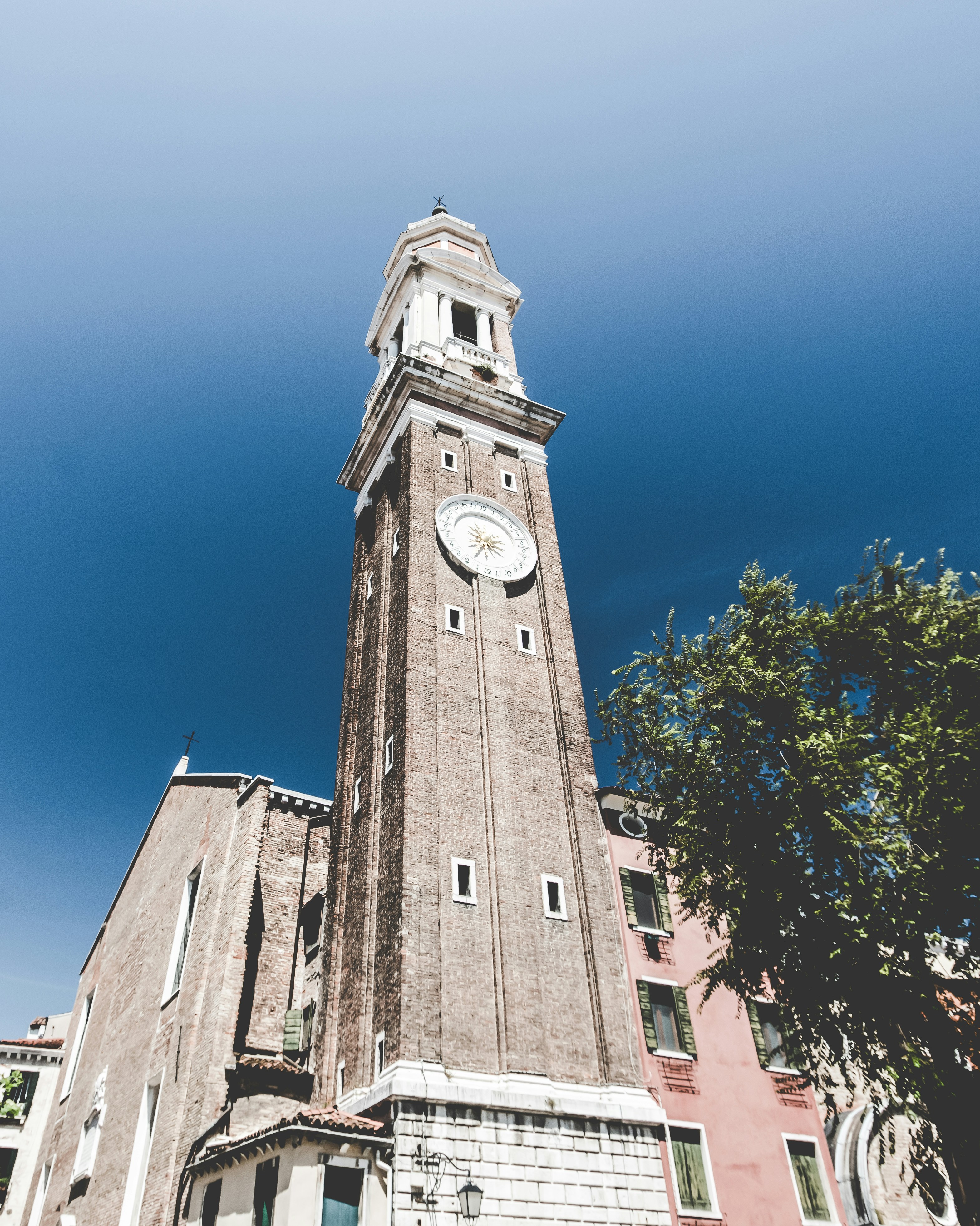 Timekeeper Above the Blue: Brick Clock Tower Against a Gradient SkyM o e