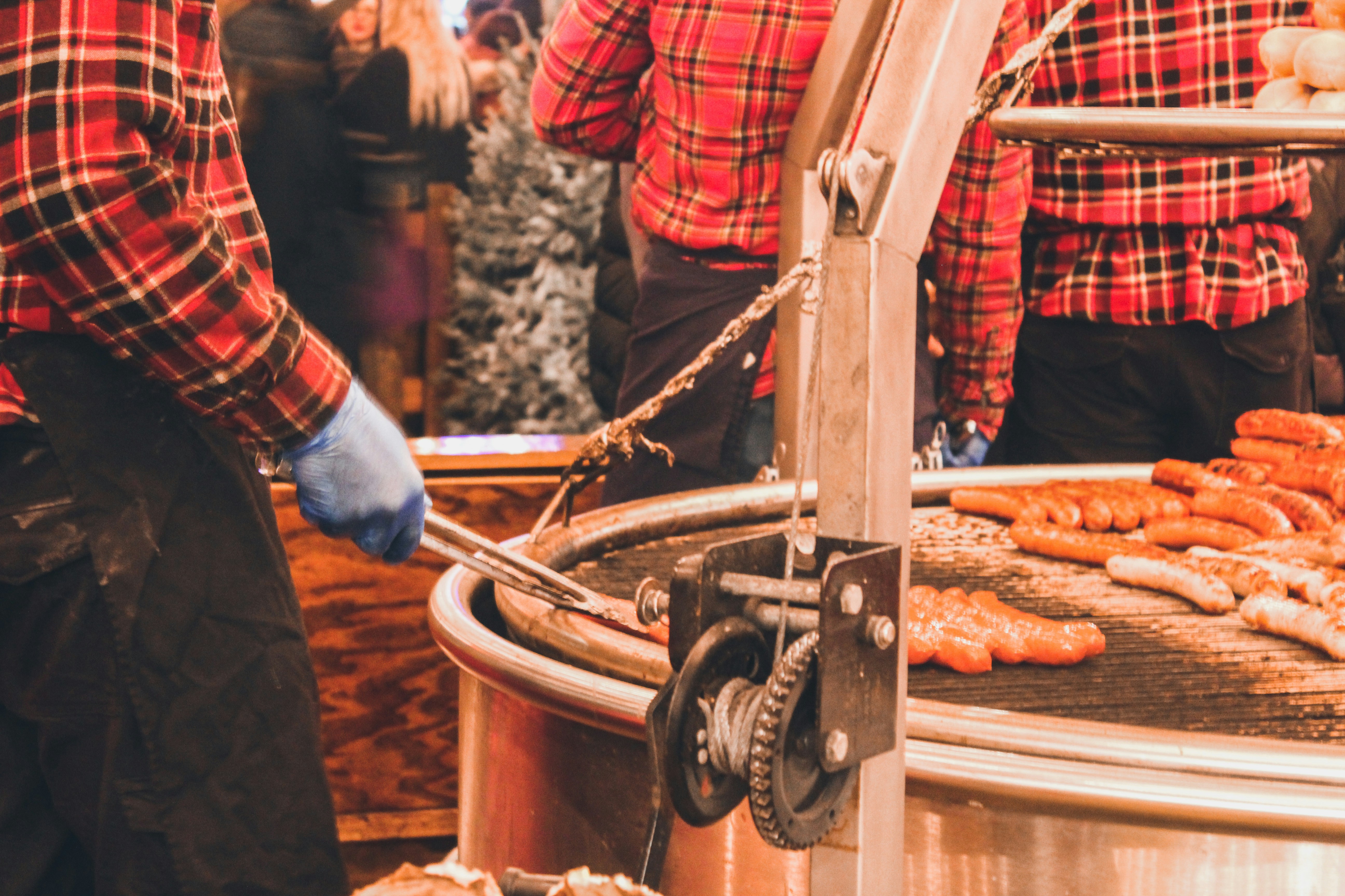 Grill Station at a Festive Market: Sausage Sizzle Under Warm Lights