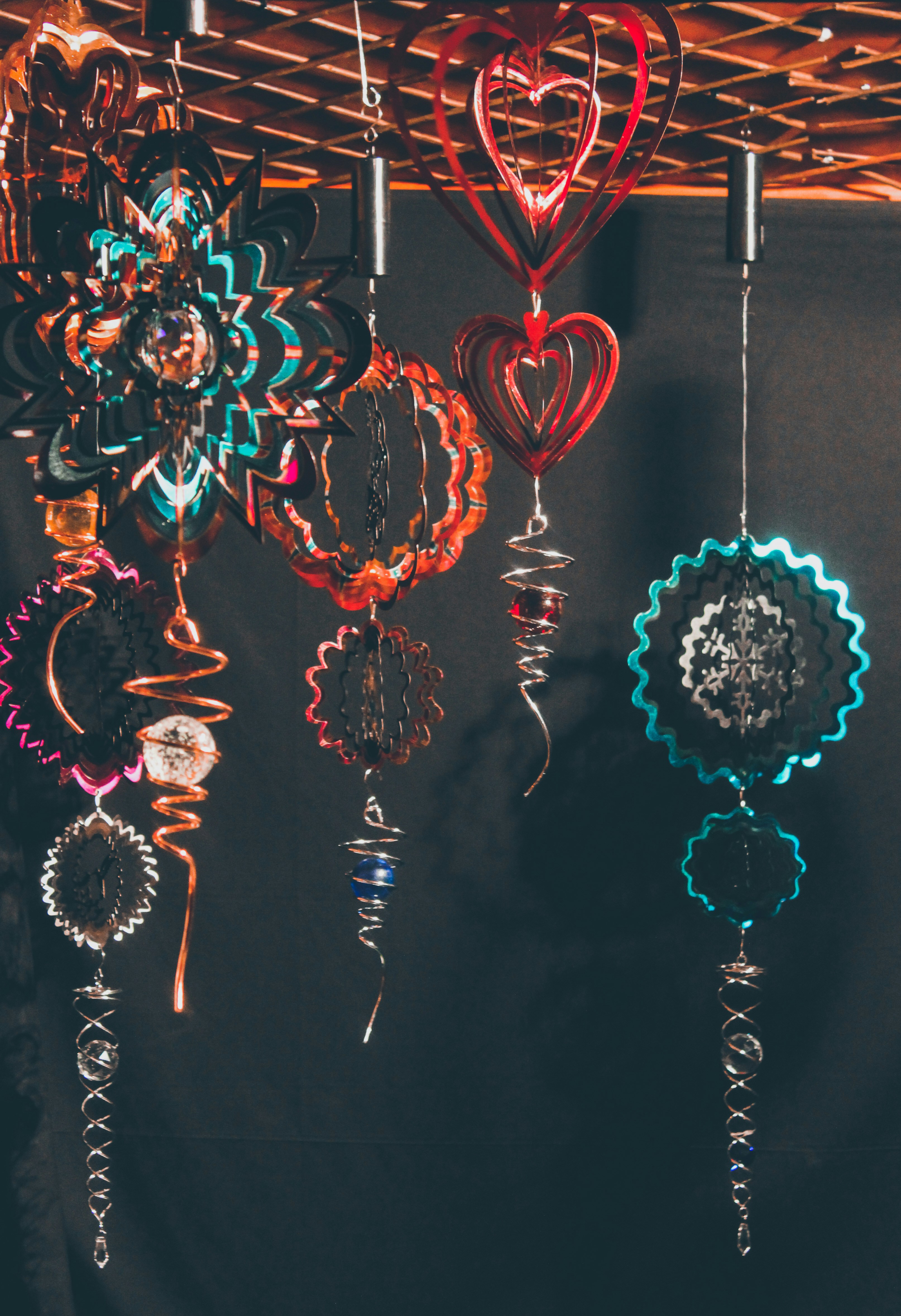 Neon Hearts and Spirals: Hanging Metal Ornaments in a Dim Studio