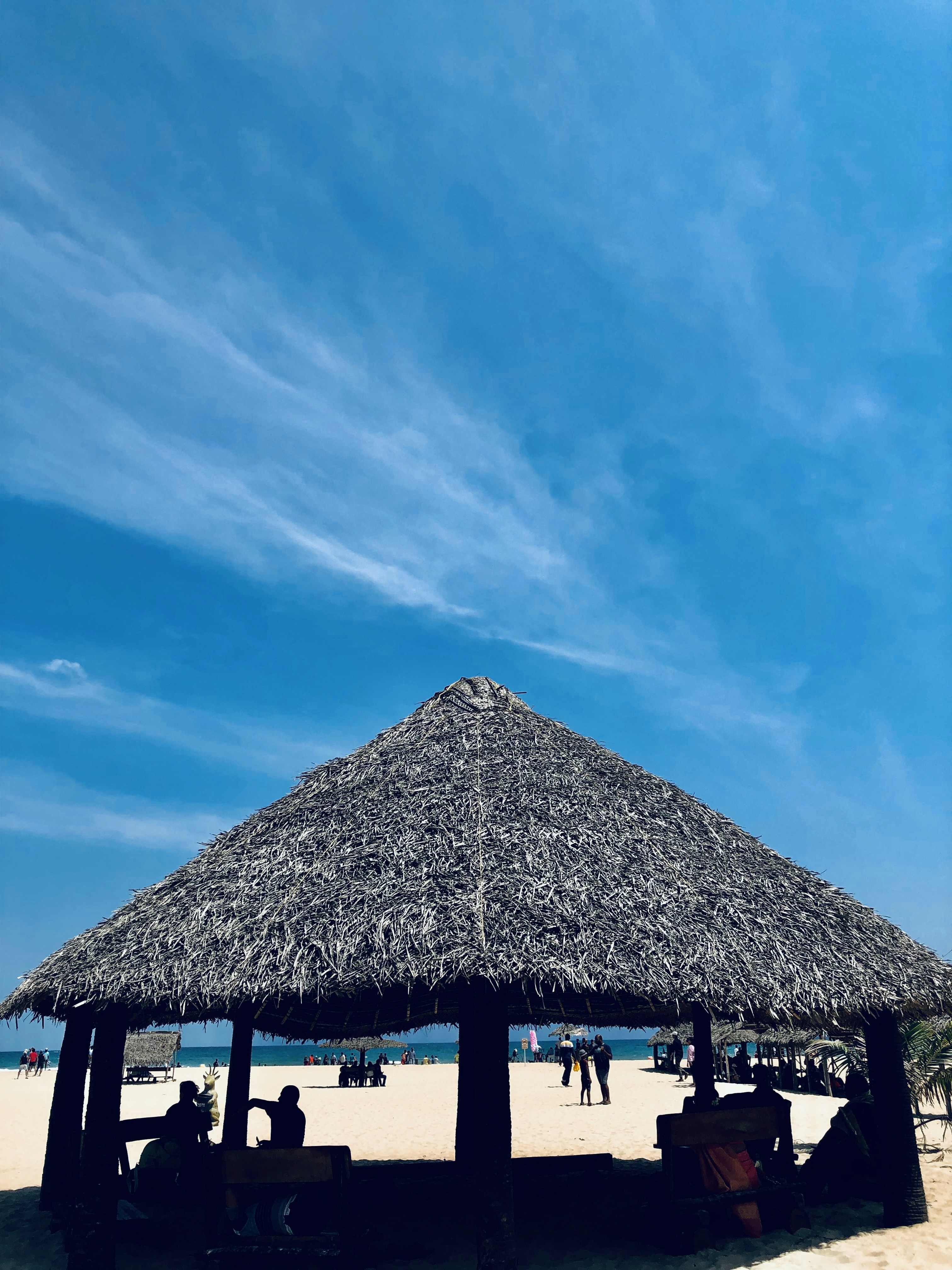 Brown hut on shore under blue sky photo – Free Land Image on Unsplash
