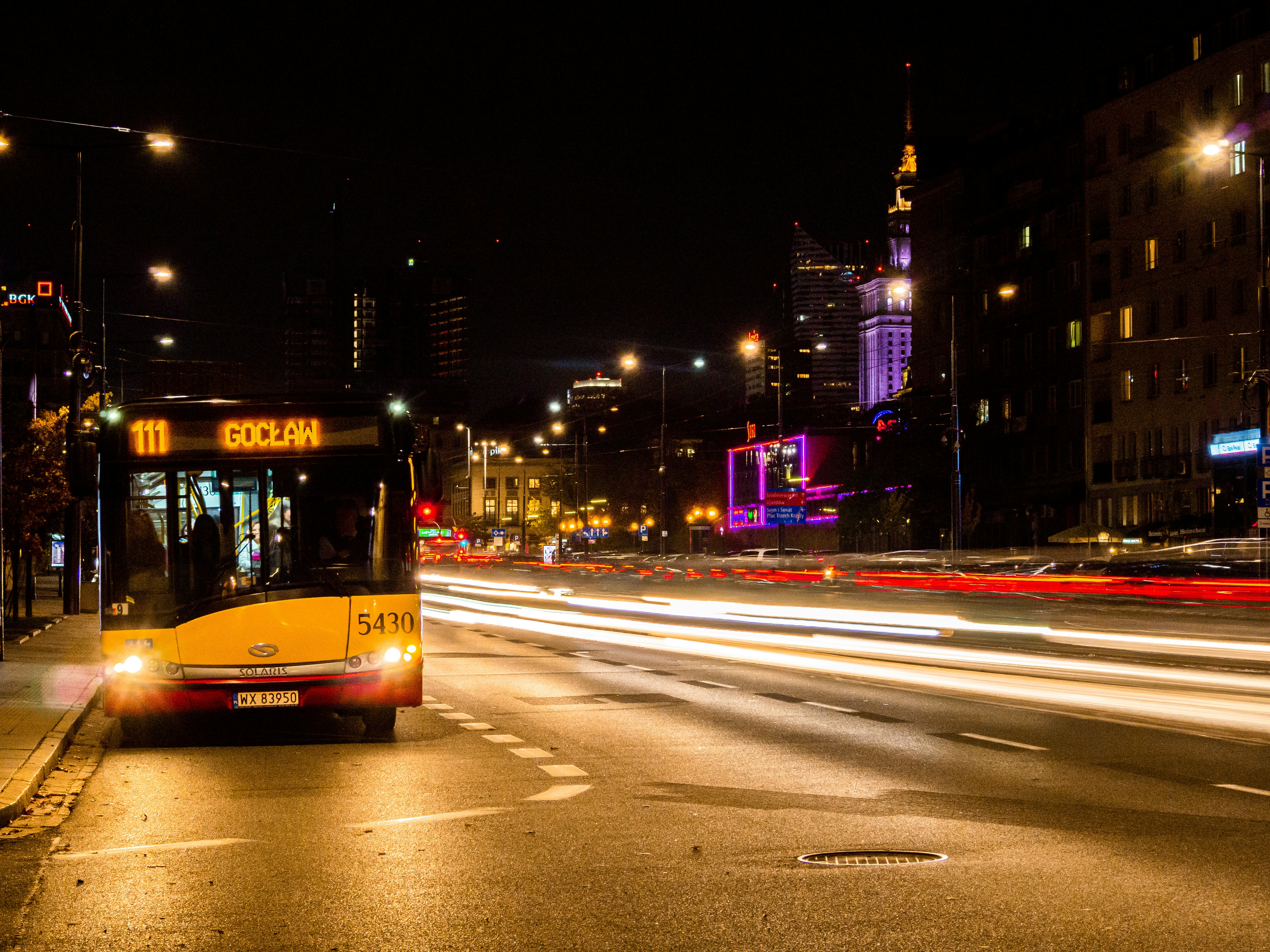 Night City Bus Stop in Motion: Neon Trails and Urban Glow