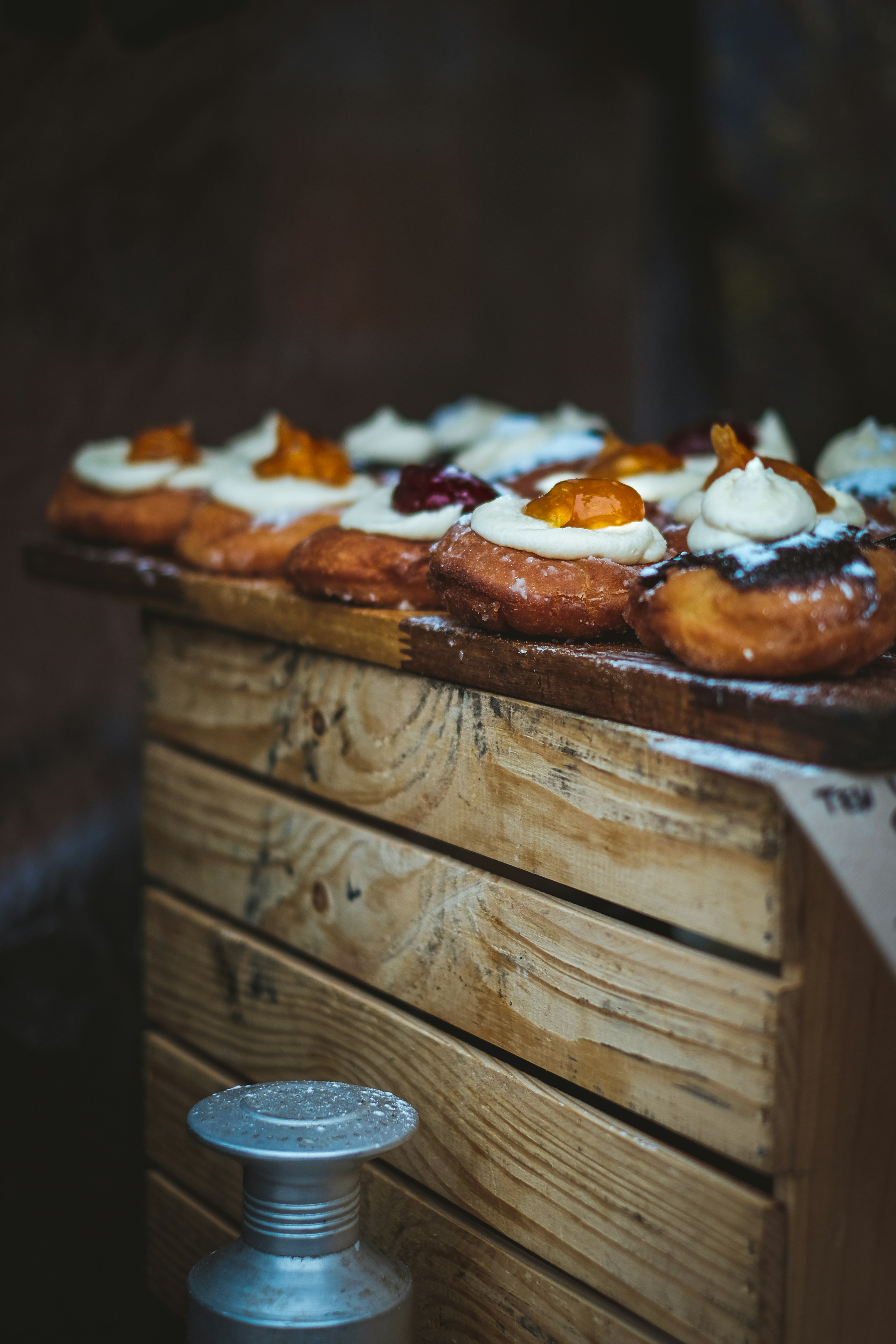 Cream-Topped Donuts on Weathered Wood: A Rustic Bakery Lineup