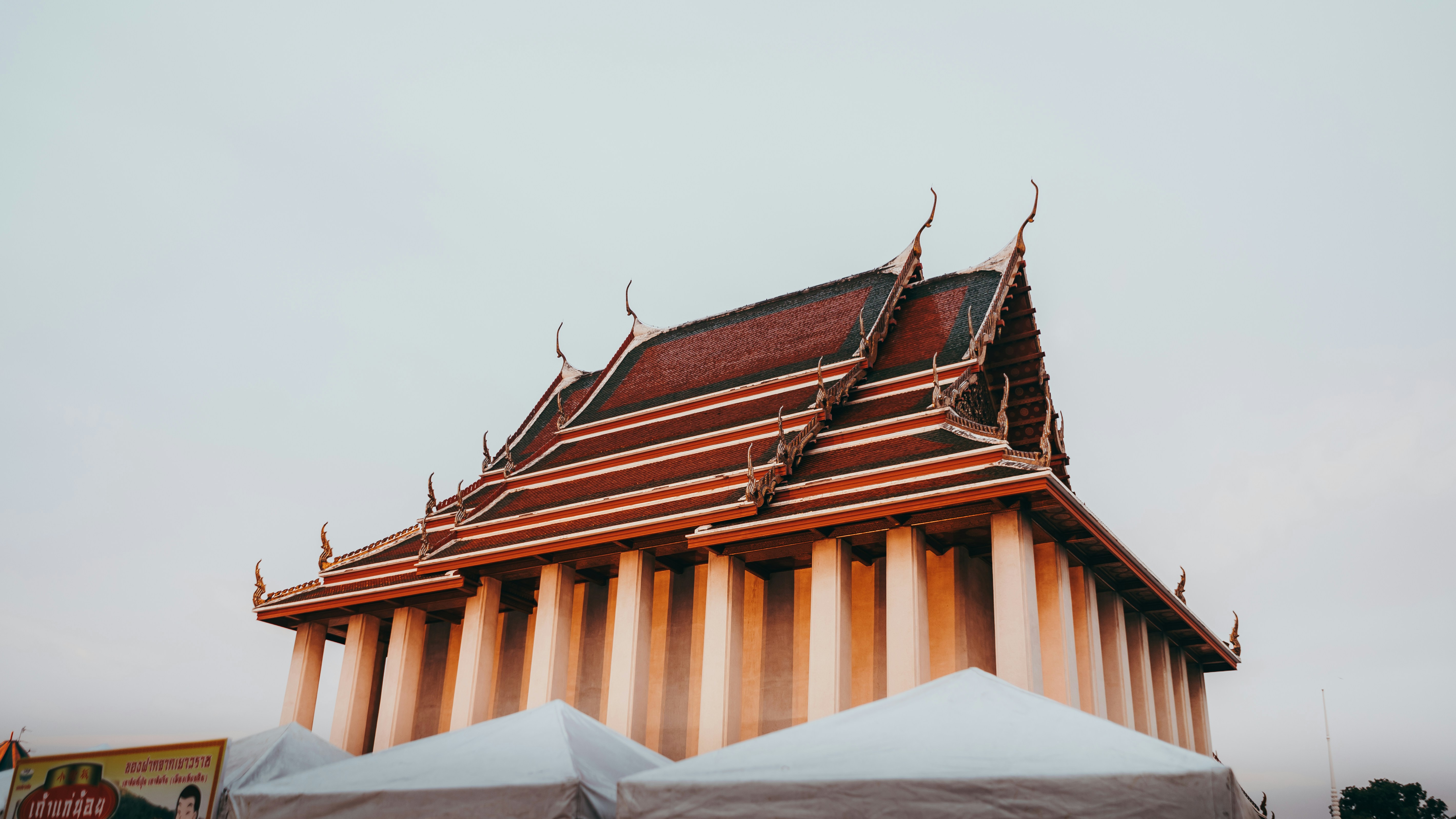Ornate Thai Temple Roof Rising Over Market Canopies