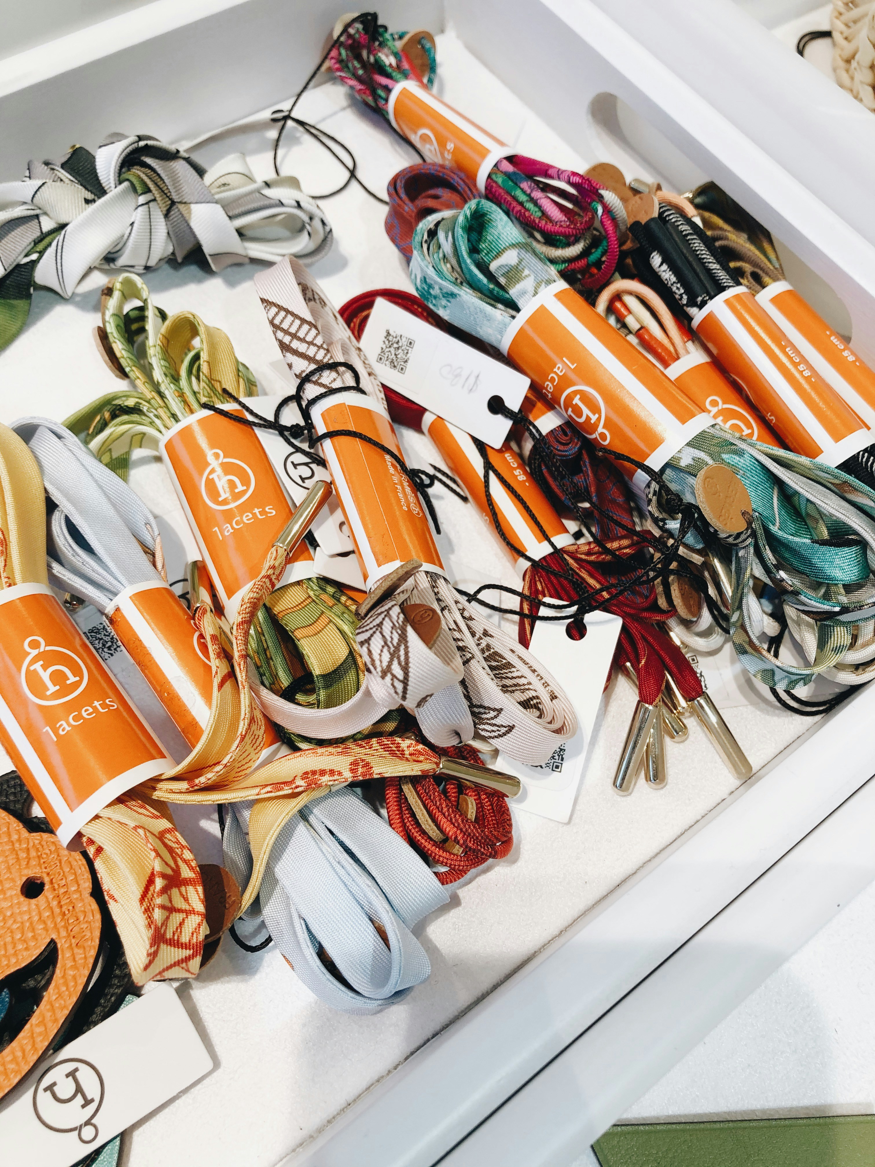 Tag-Tangle: Orange Tags Dominate a Drawer of Colorful Straps