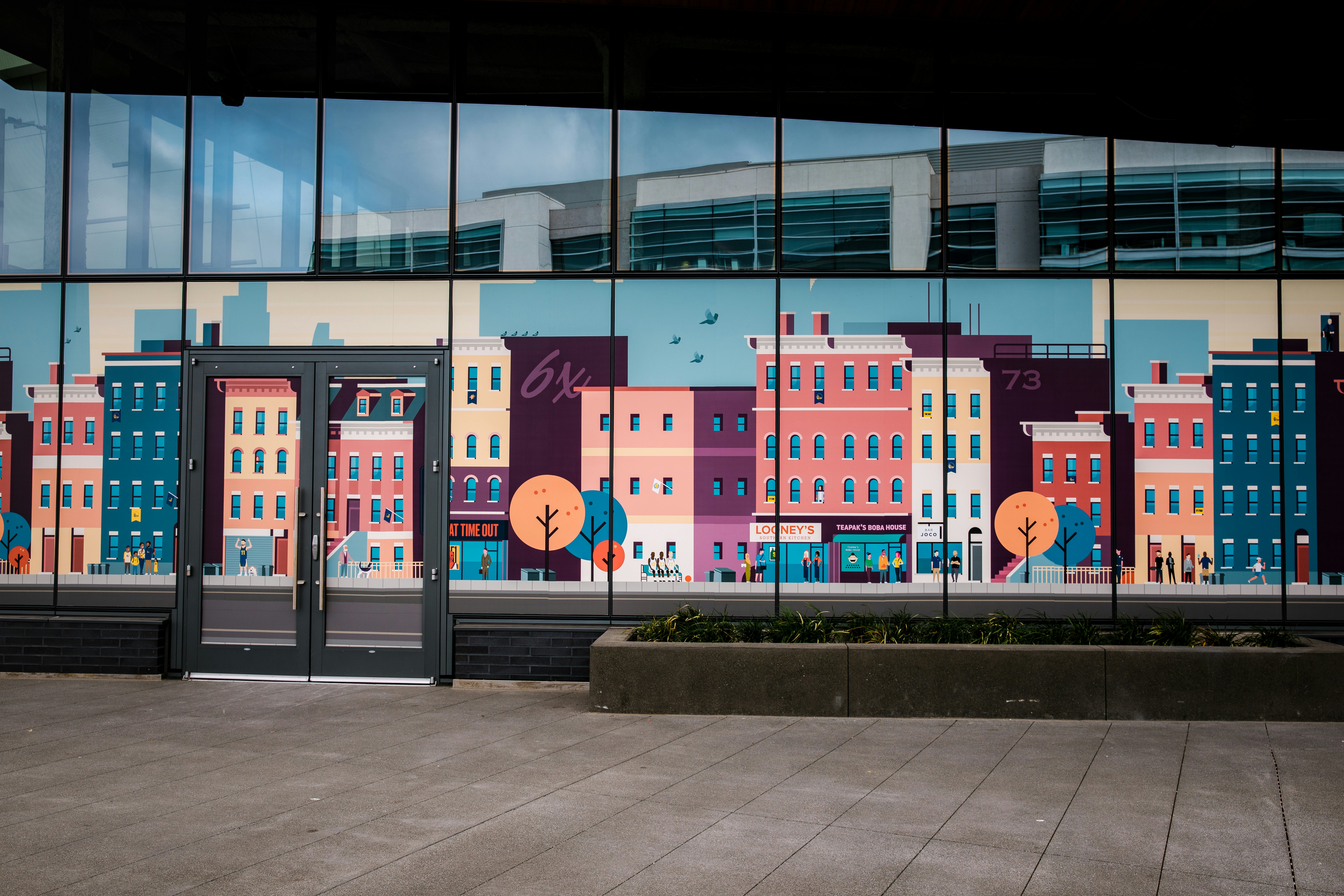 A large building with a mural of buildings on it photo – Free Door ...