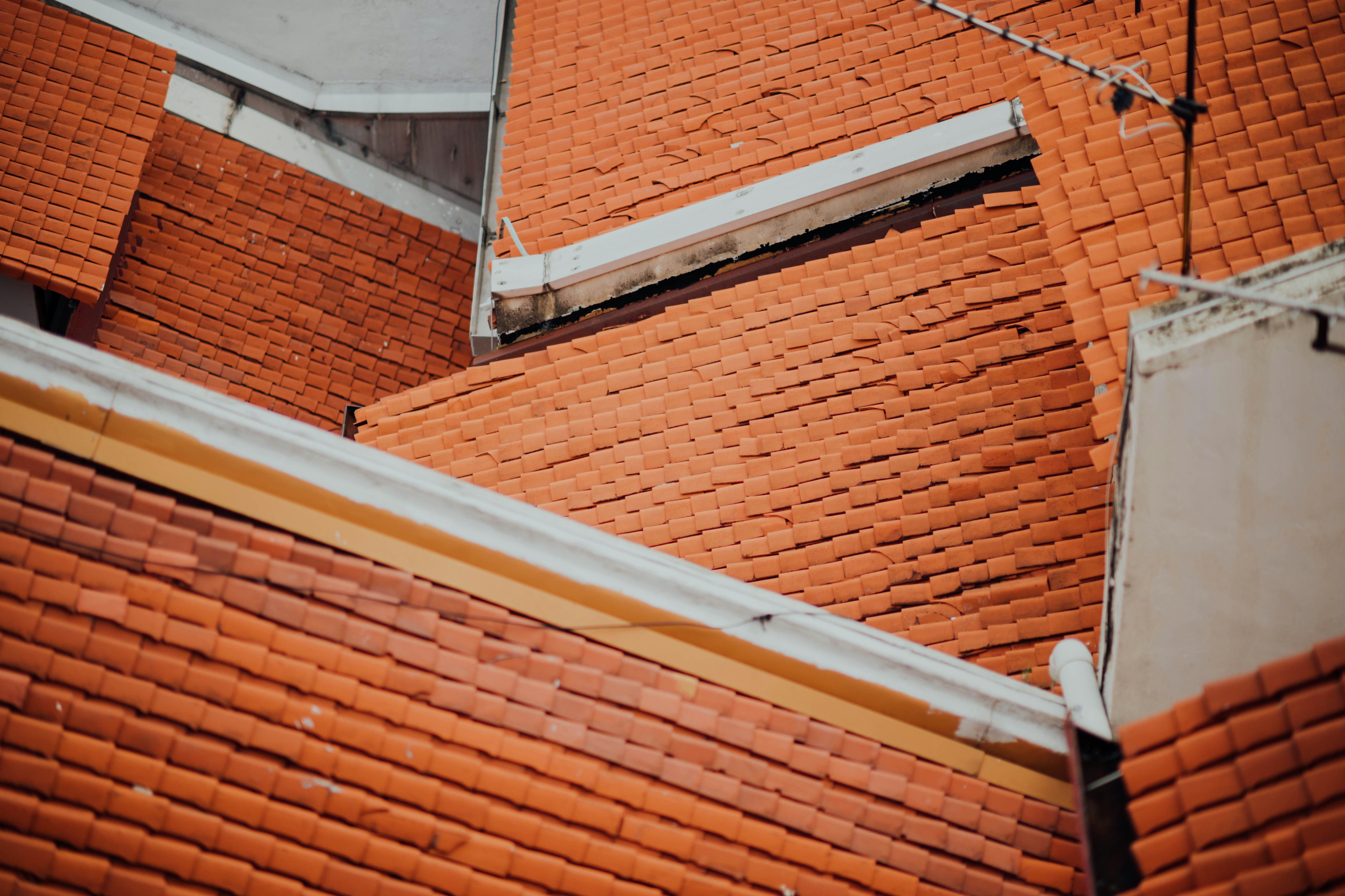 Intricate arrangement of terracotta roof tiles showcasing geometric patterns and textures. The image highlights the craftsmanship of traditional roofing.
