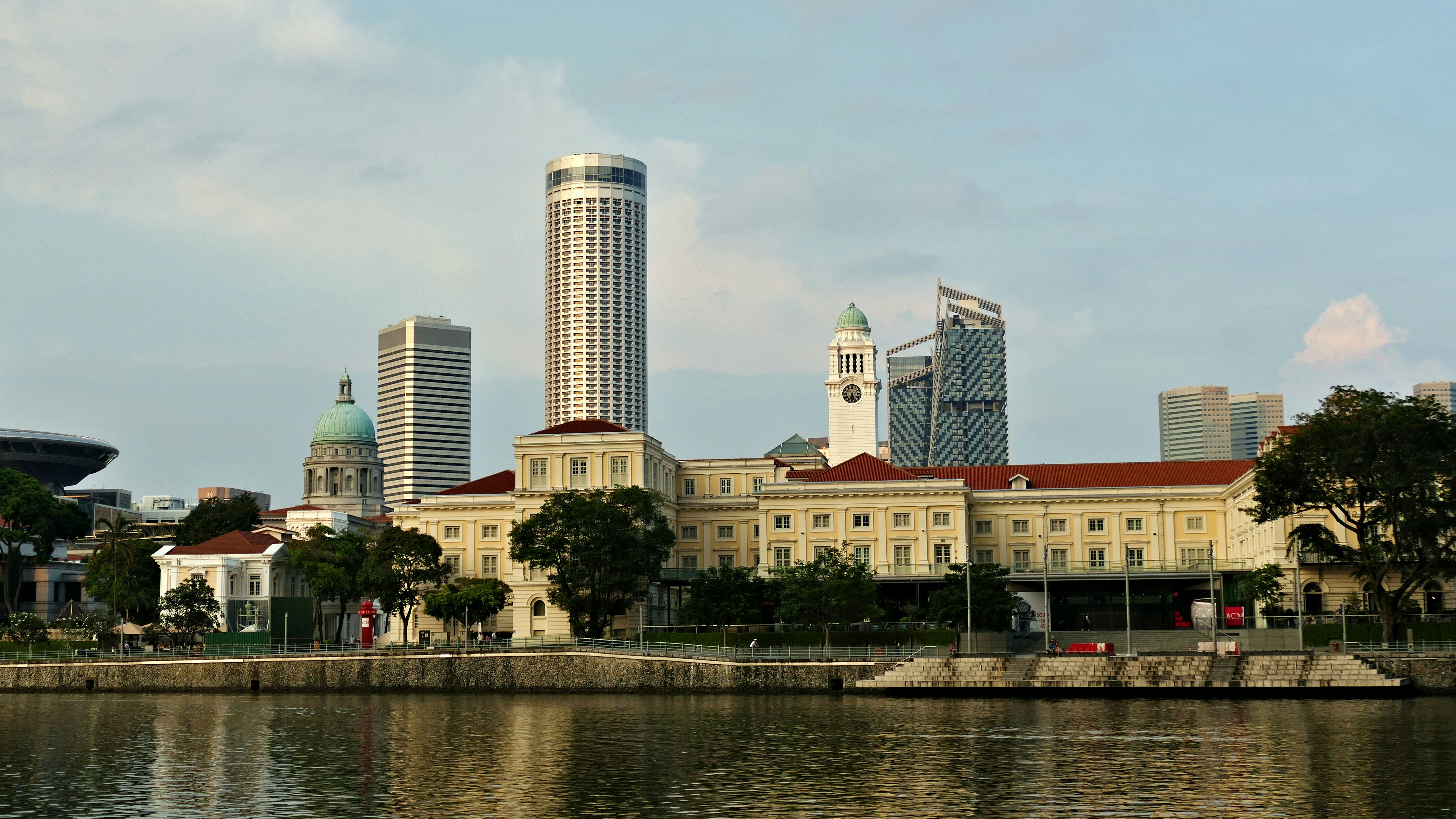 Historic architecture juxtaposed with modern skyscrapers along a serene waterfront.
