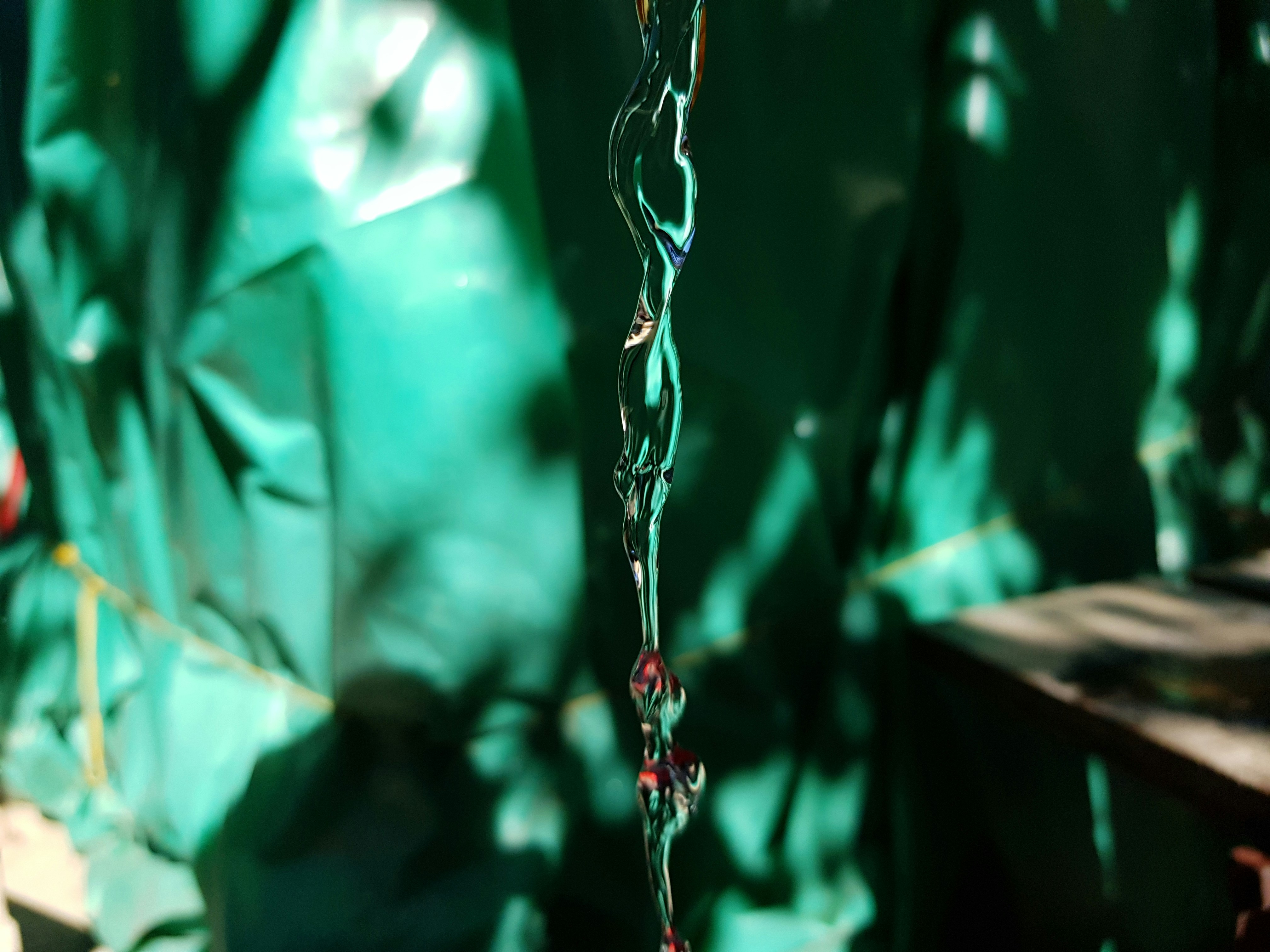 Emerald Thread: A slender water cascade through jungle-green blur