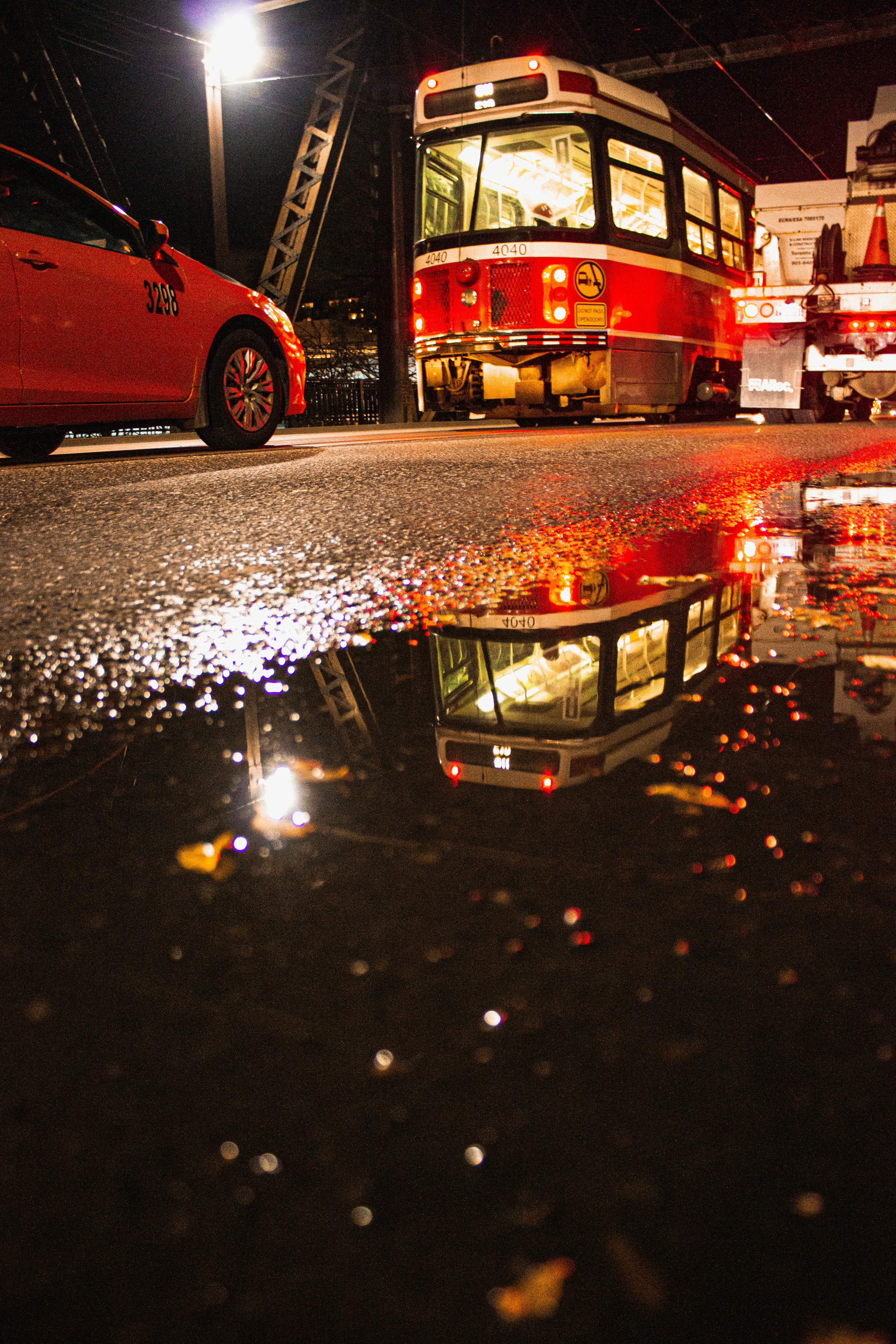 Red vehicle passing near water puddle on road at night photo – Free ...