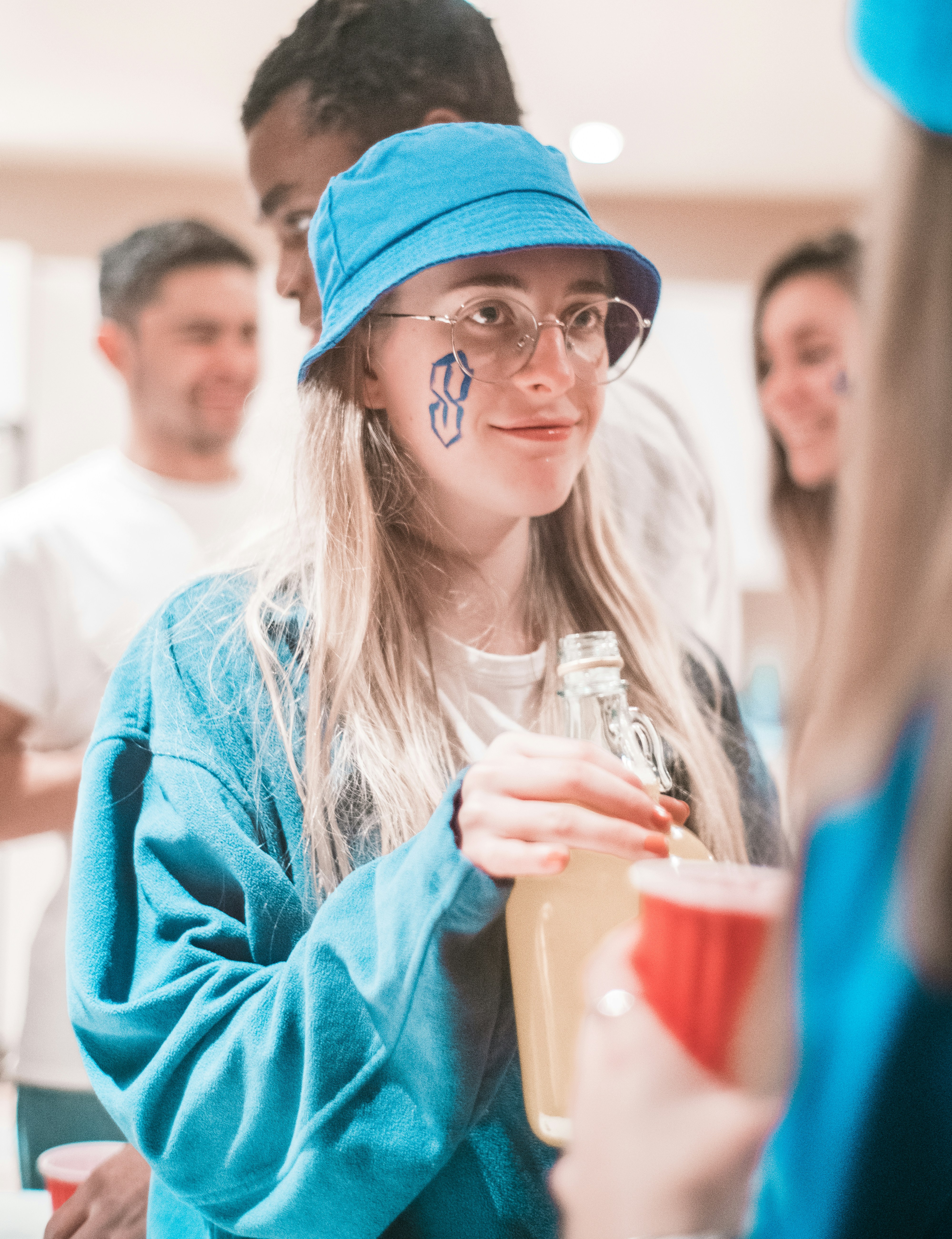 Blue Bucket Portrait Among Friends: a quiet glow at a casual party