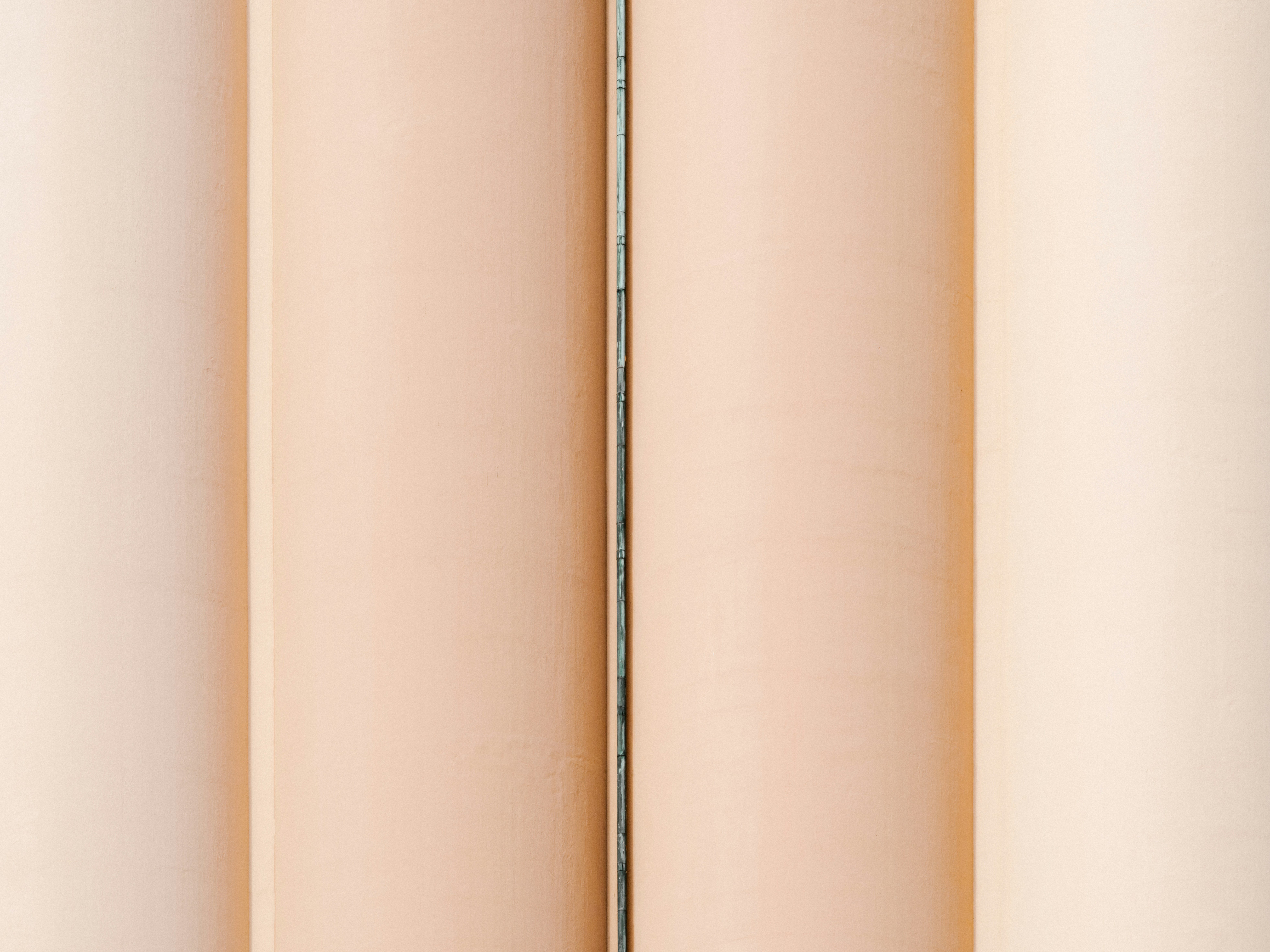 Vertical alignment of soft peach-toned panels with a subtle central seam.