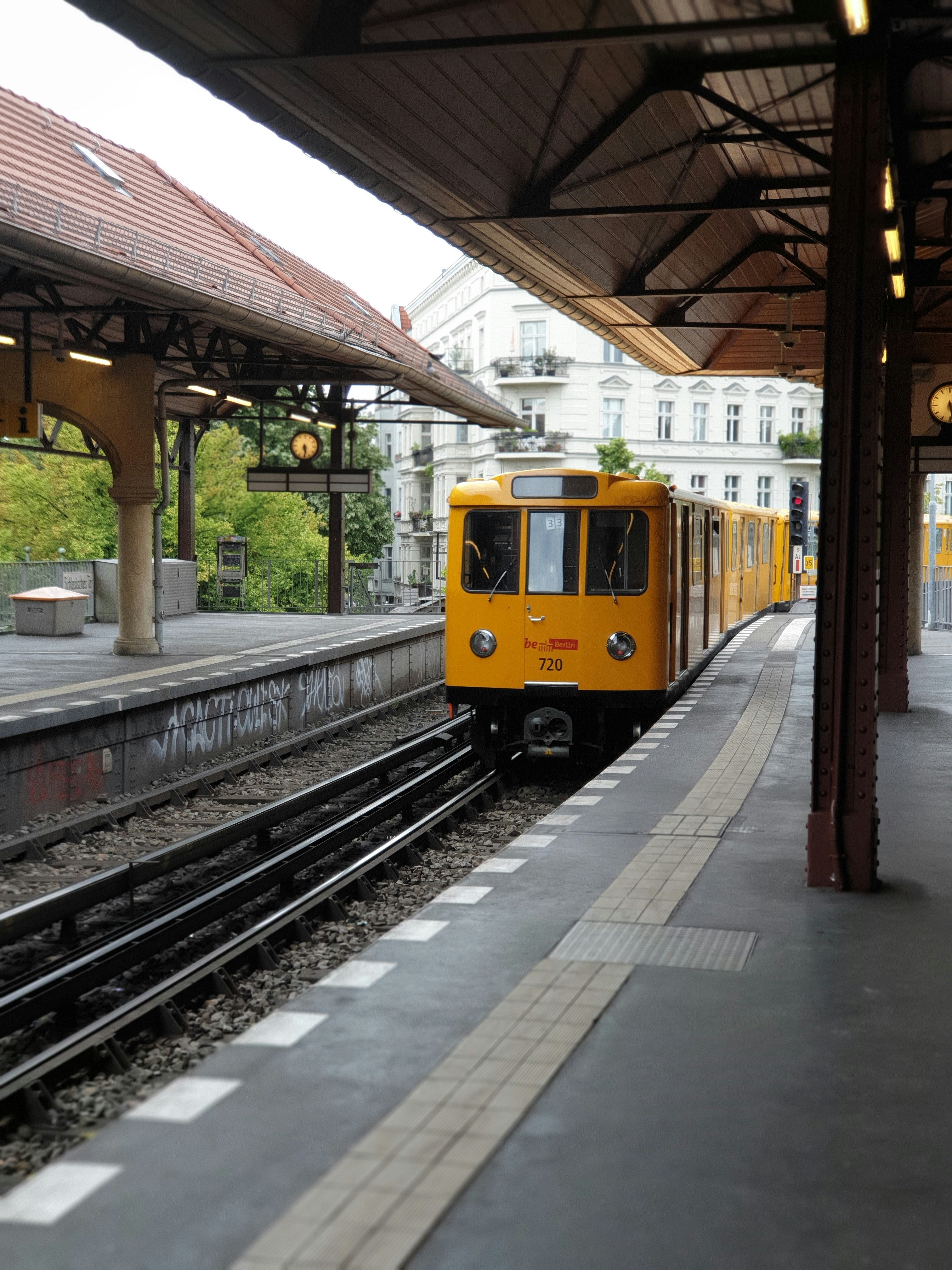 A yellow train pulling into a train station photo – Free Railway Image ...