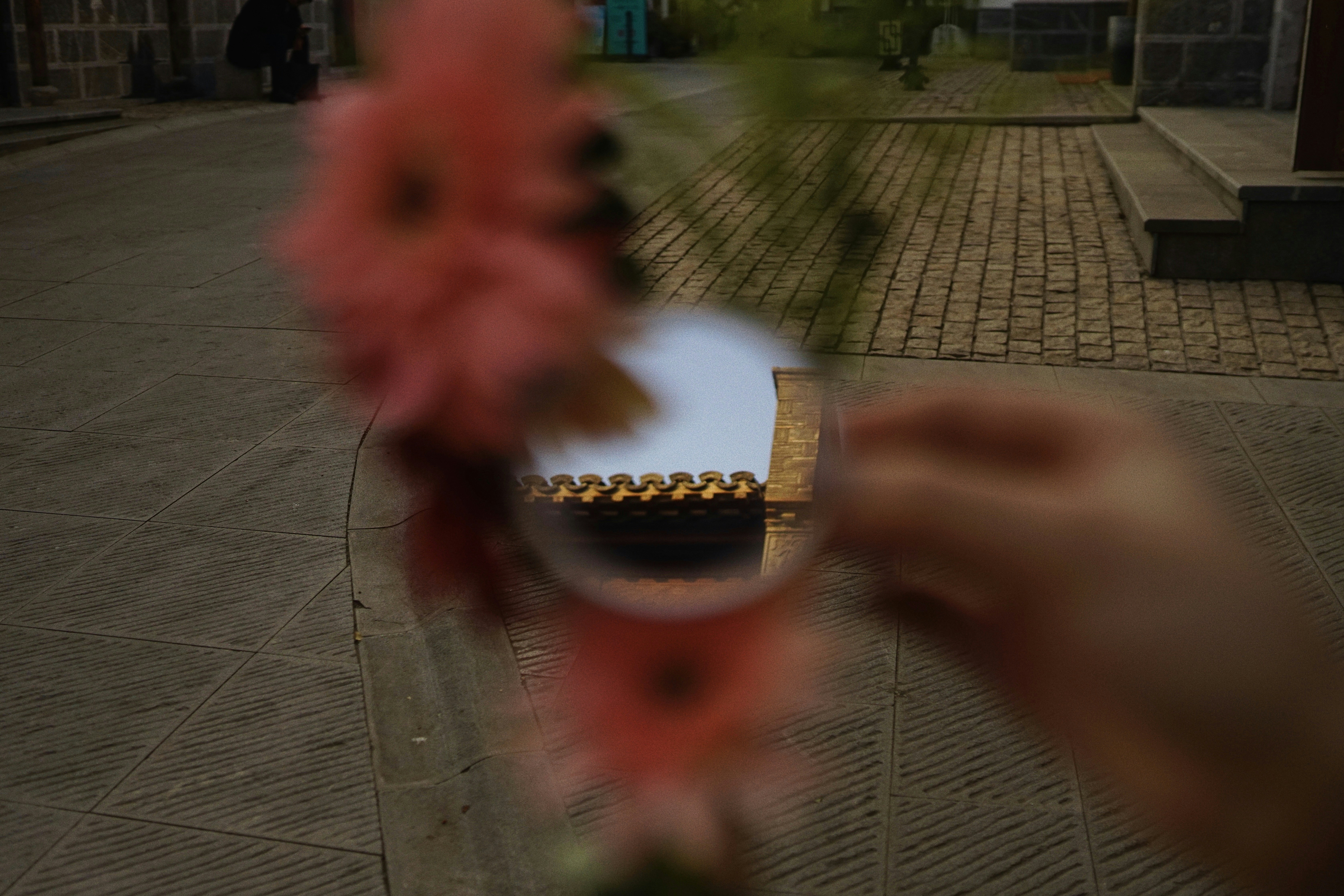 Urban Quiet through a Rosy Blur: A Hand-Held Frame in a Cobblestone Courtyard