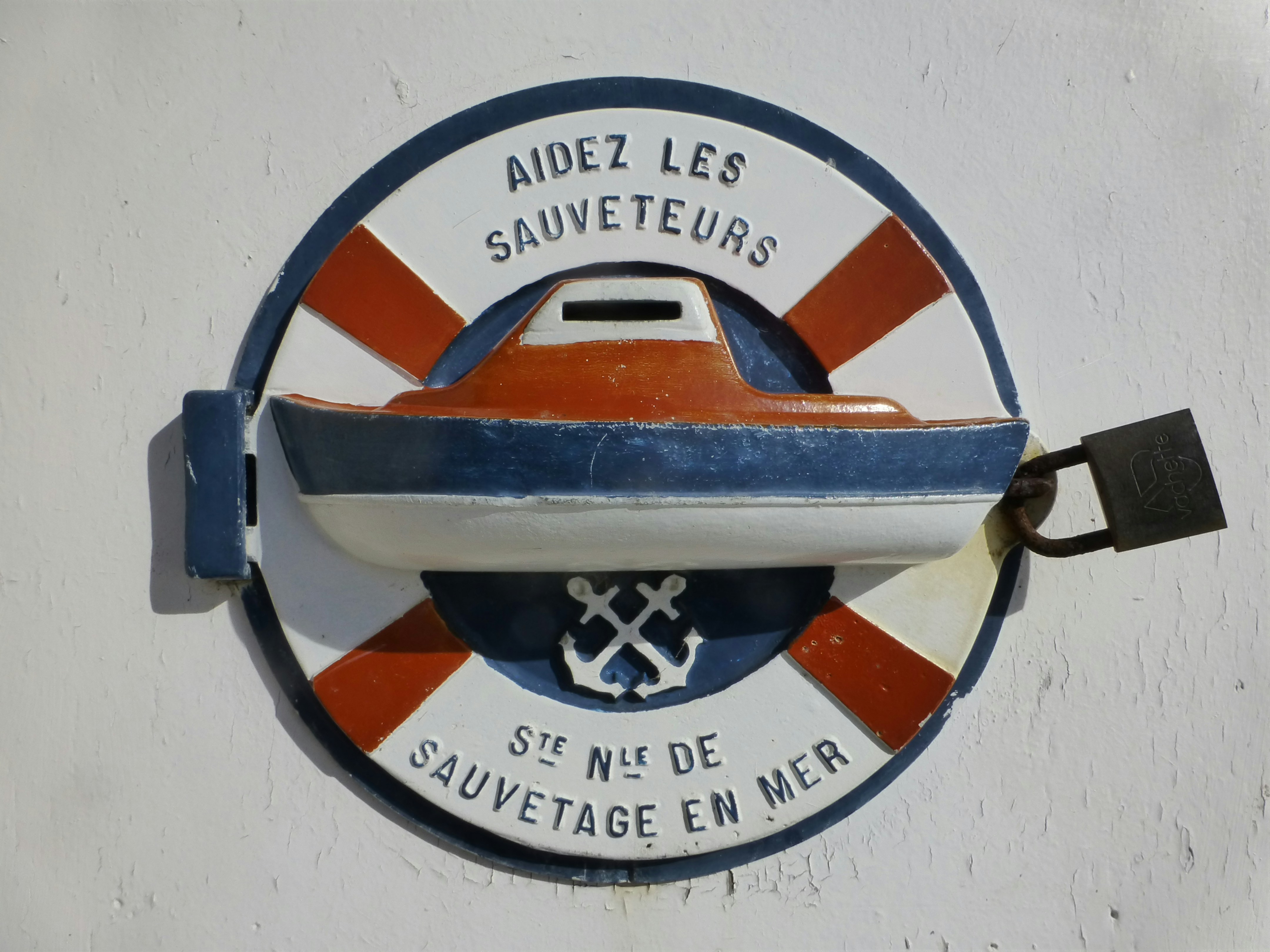 Colorful lifebuoy featuring a boat design and a message urging support for rescuers at sea.