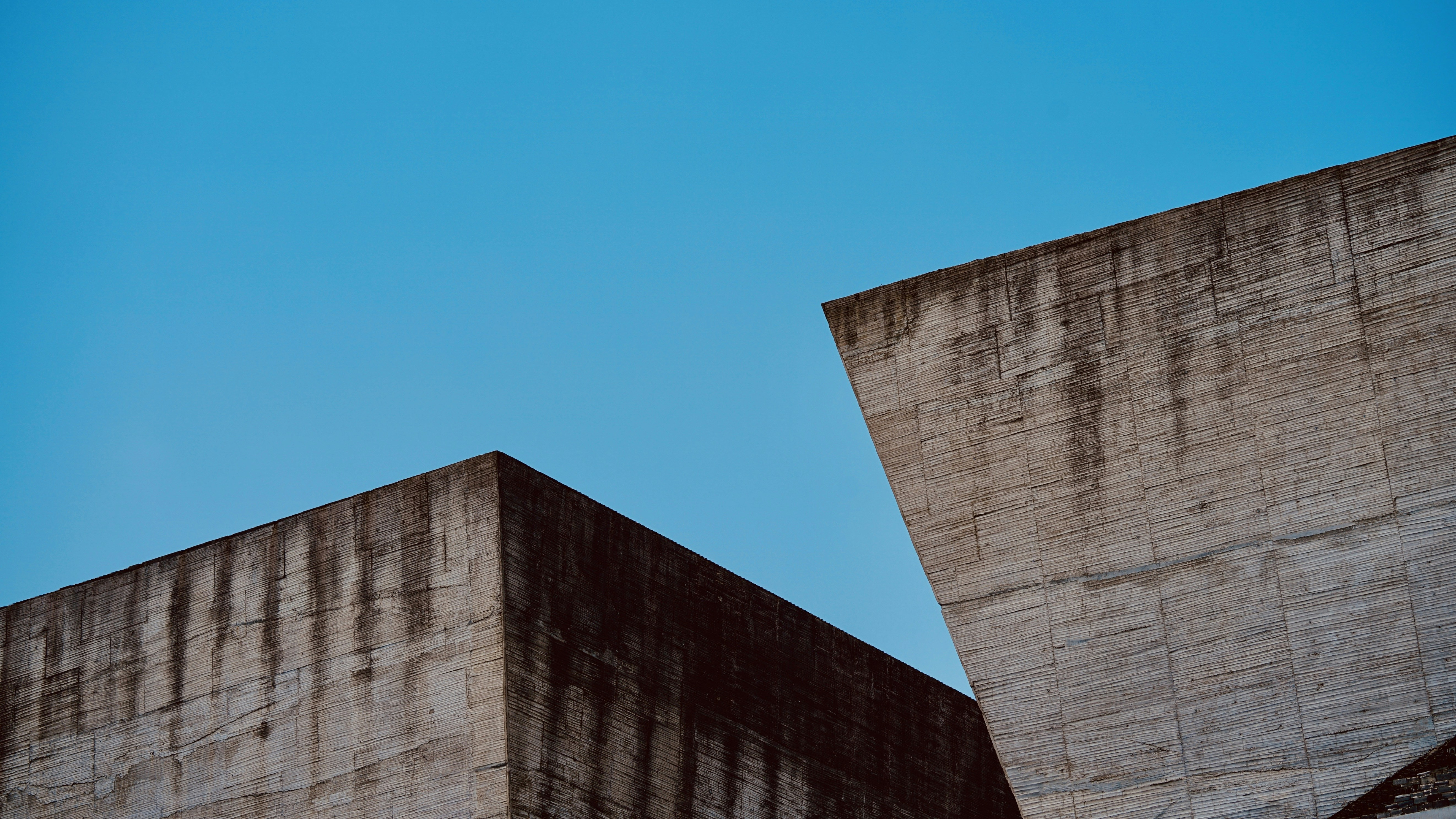 Concrete architectural structures rise against a clear blue sky.