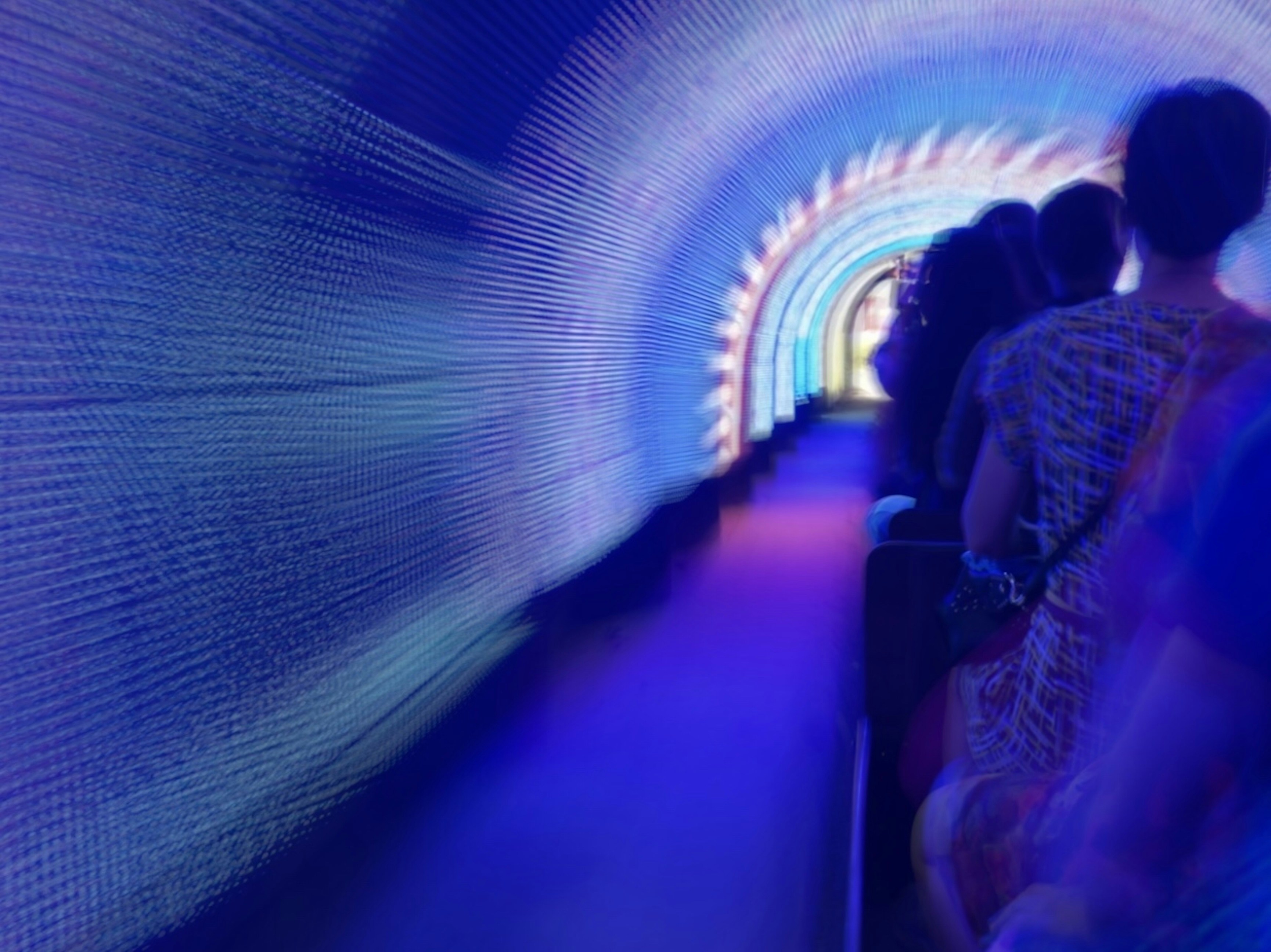 Neon-Tunnel Lineup: Blurred Figures in a Night Drive