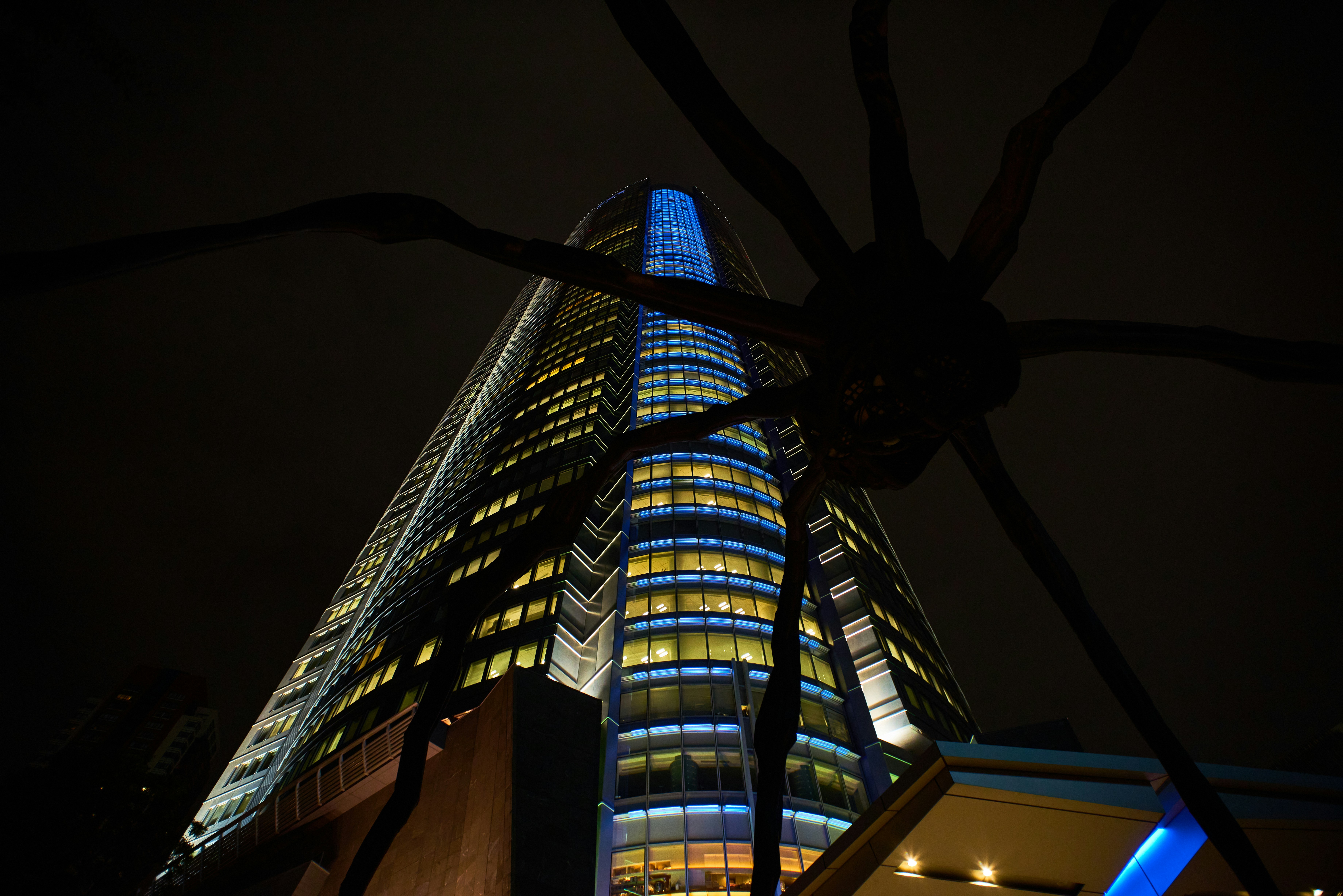 Blue Crowned Skyscraper Framed by a Night-Spider Silhouette