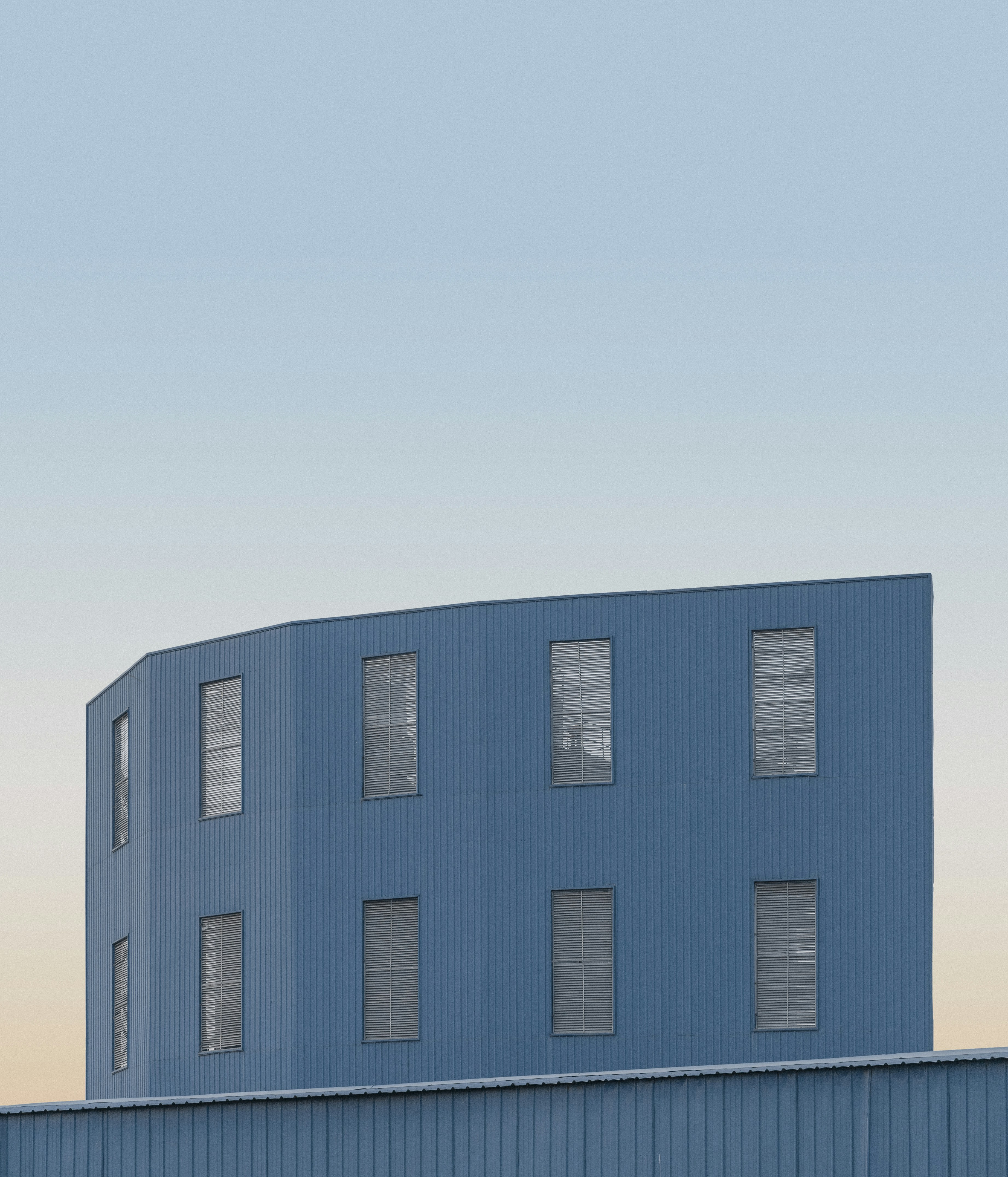 A large blue building with many windows on top of it photo – Free Blue ...