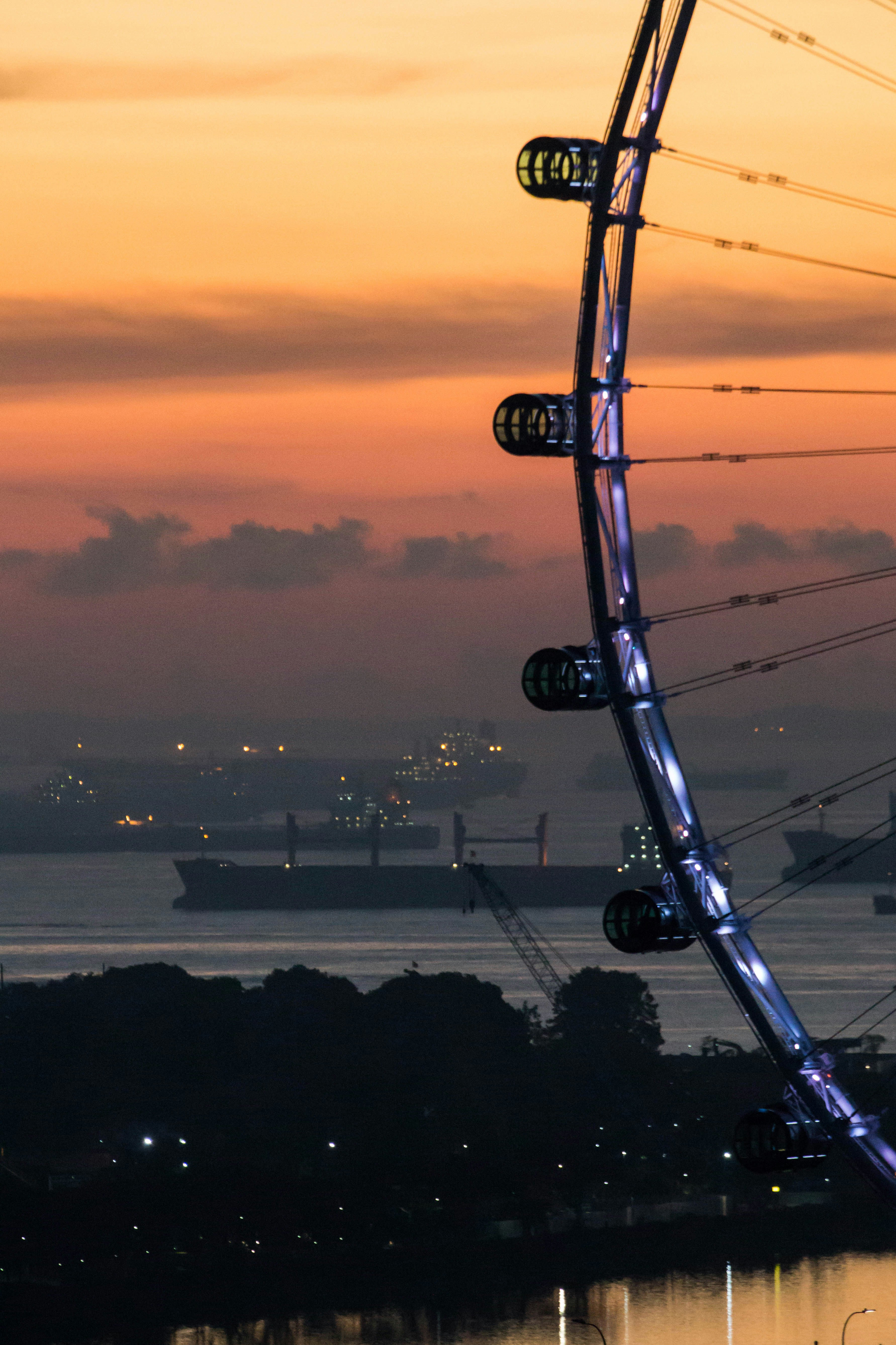 Twilight Rings Over the Harbor: A Ferris Wheel Glows Against Cargo Ships