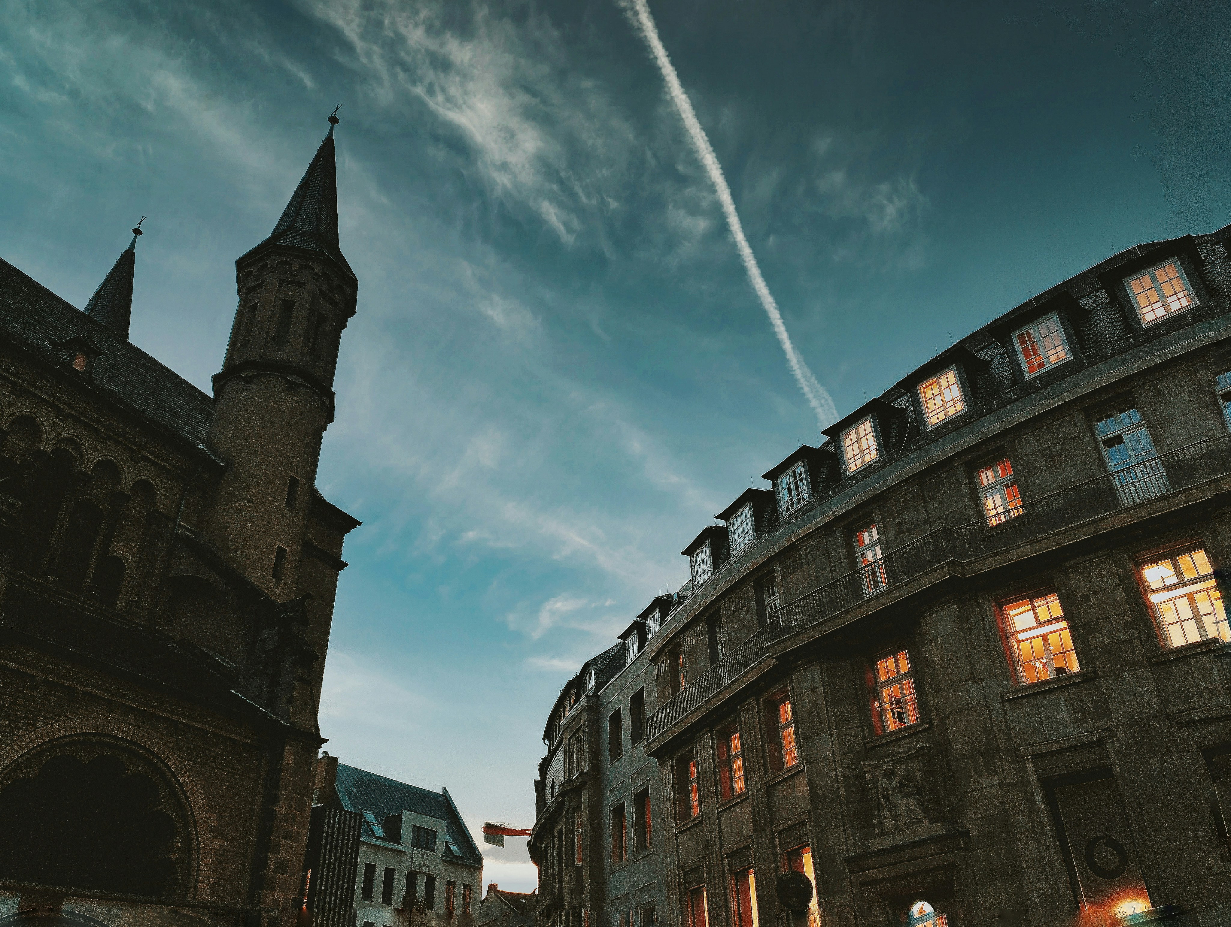 Clock tower and curved building under a streaked evening sky.