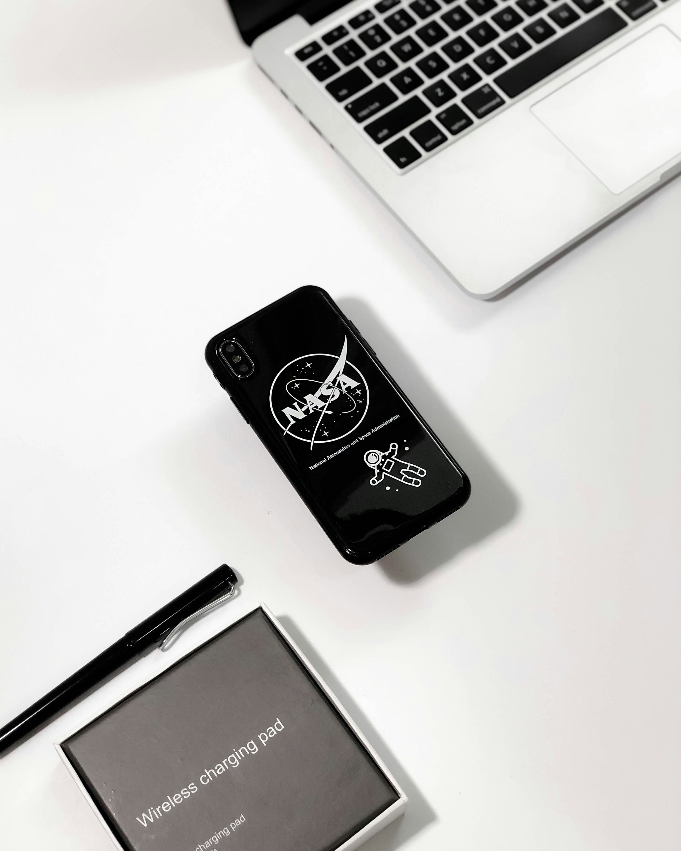 Black NASA-printed phone case near MacBook Pro photo – Free Iphone ...