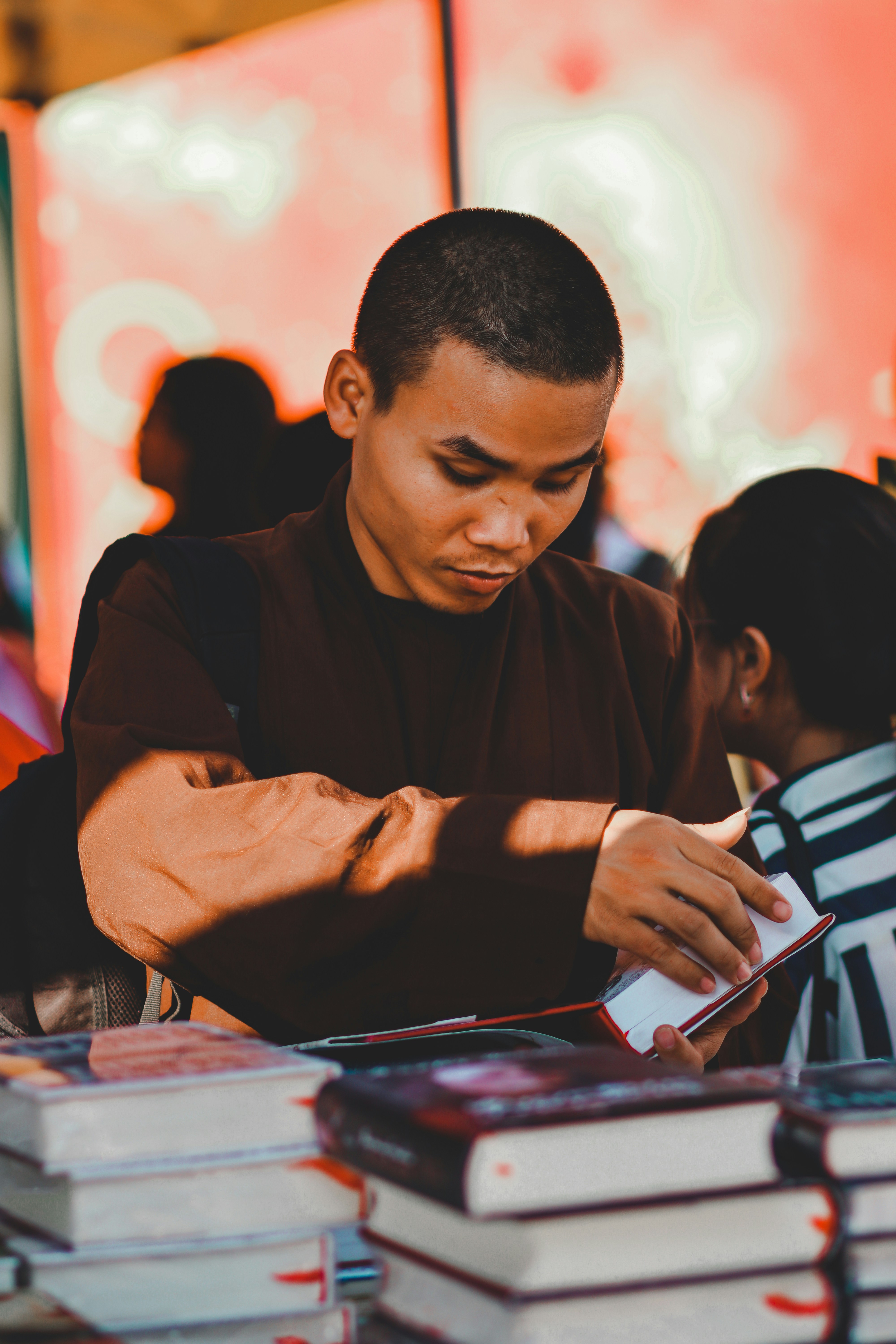 Neon-Glow Focus at a Book Stall: Hands Hovering Over Pages