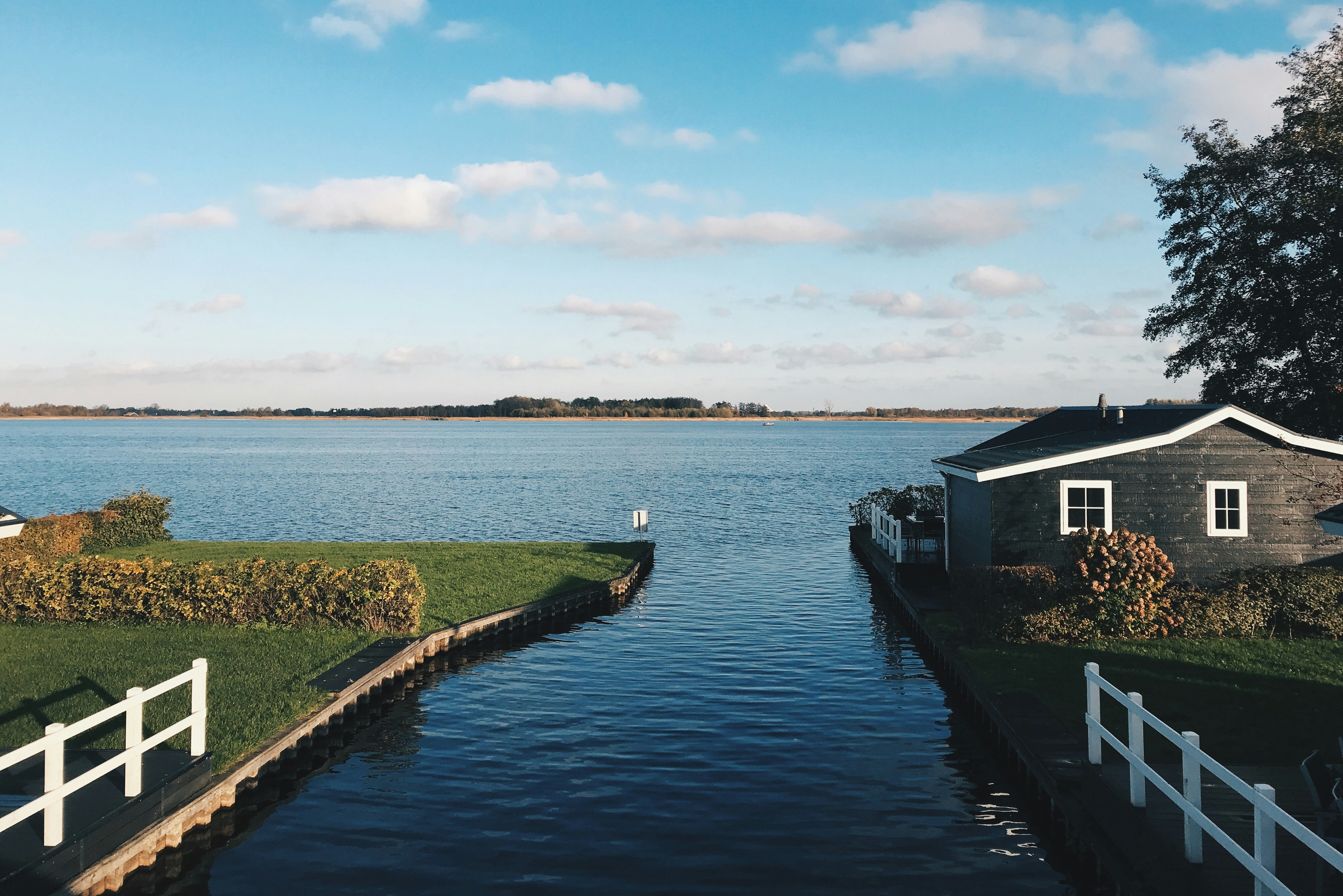 Horizon Channel: A Quiet Canal Framed by a Boathouse and White Fences