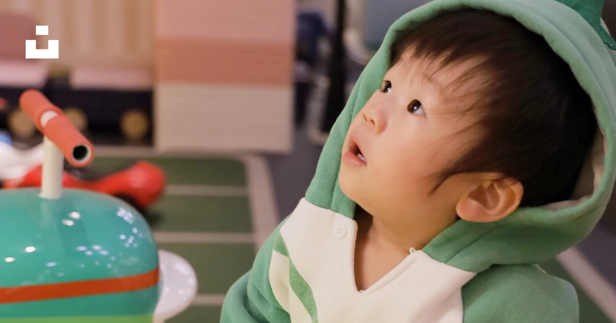 녹색 까마귀를 입고 노란 자동차 장난감을 타고 있는 소년 사진 Unsplash의 무료 탁아소 이미지