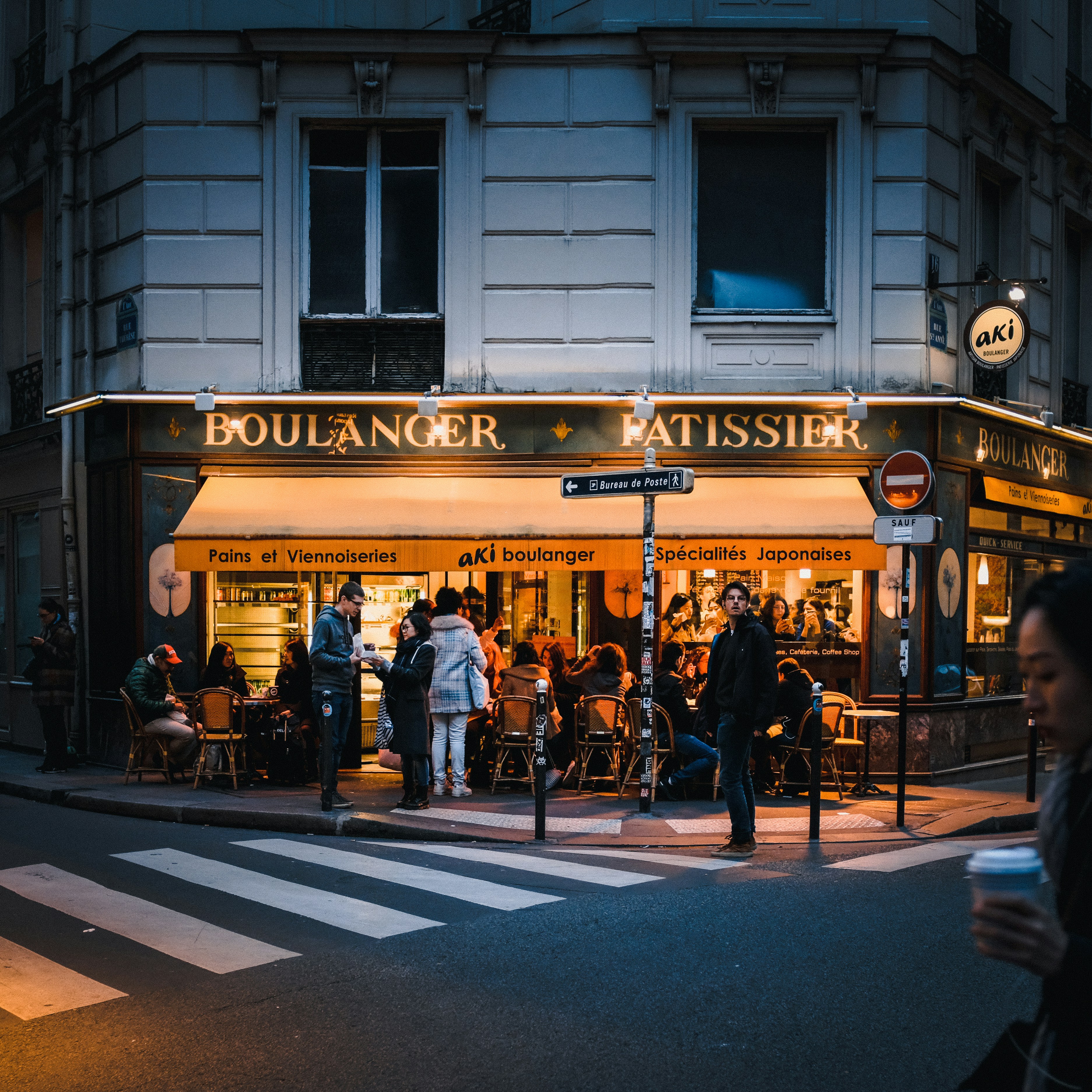 Amber Glow at a Parisian Boulangerie: Evening Buzz on a Corner Café