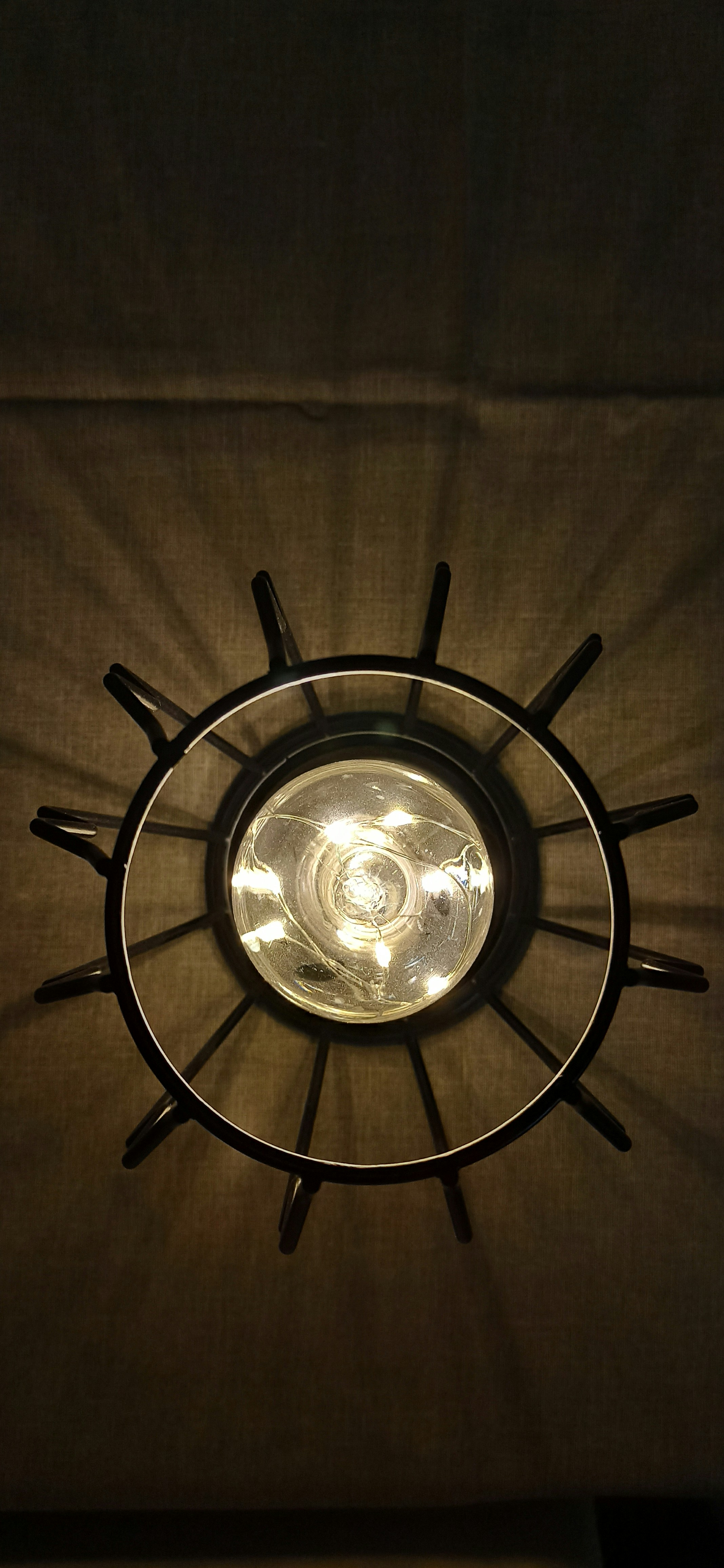 A circular light fixture casts intricate shadows on a textured surface, highlighting the interplay of illumination and design.