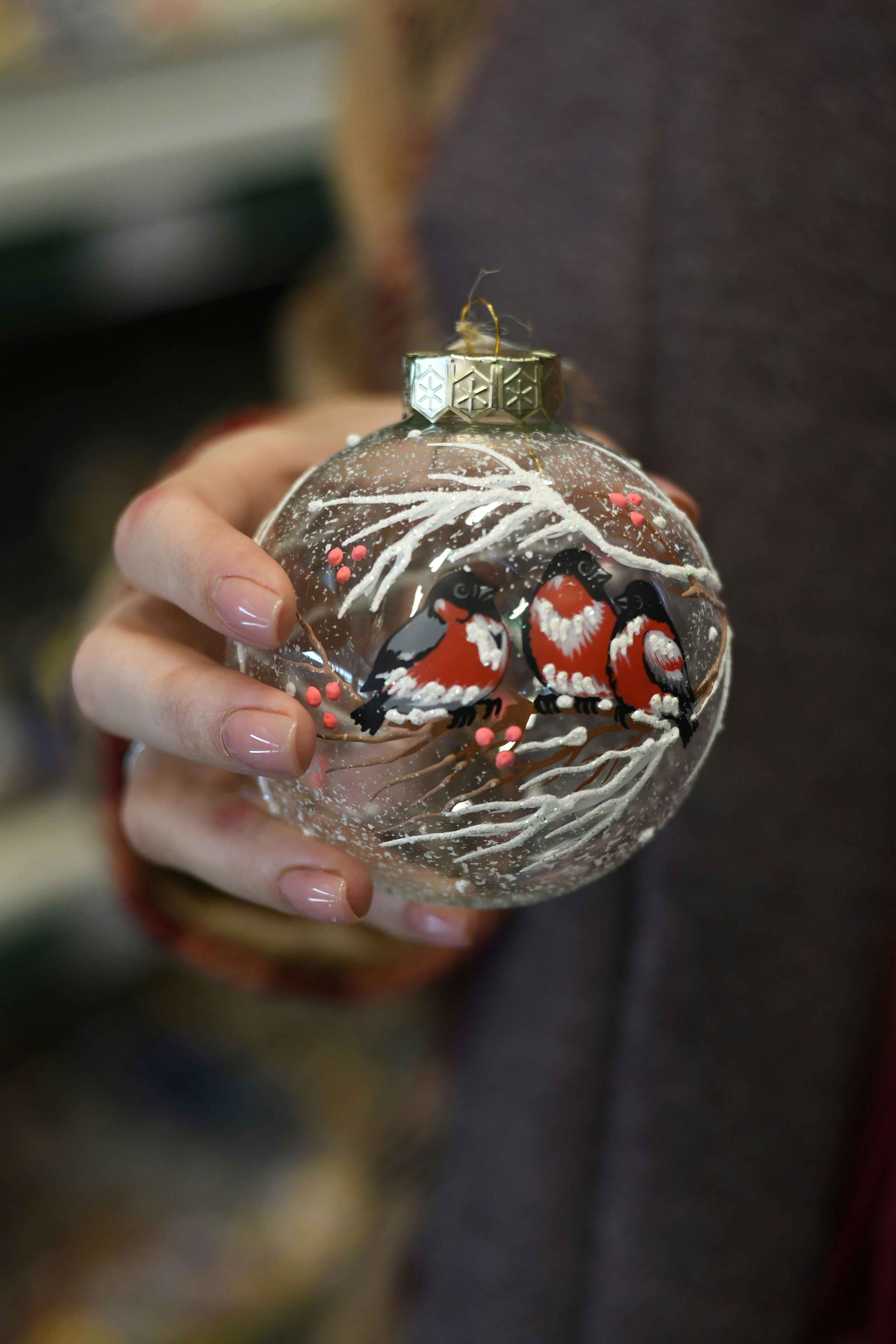 Three Red-Breasted Birds Adorn a Frosted Glass Ornament