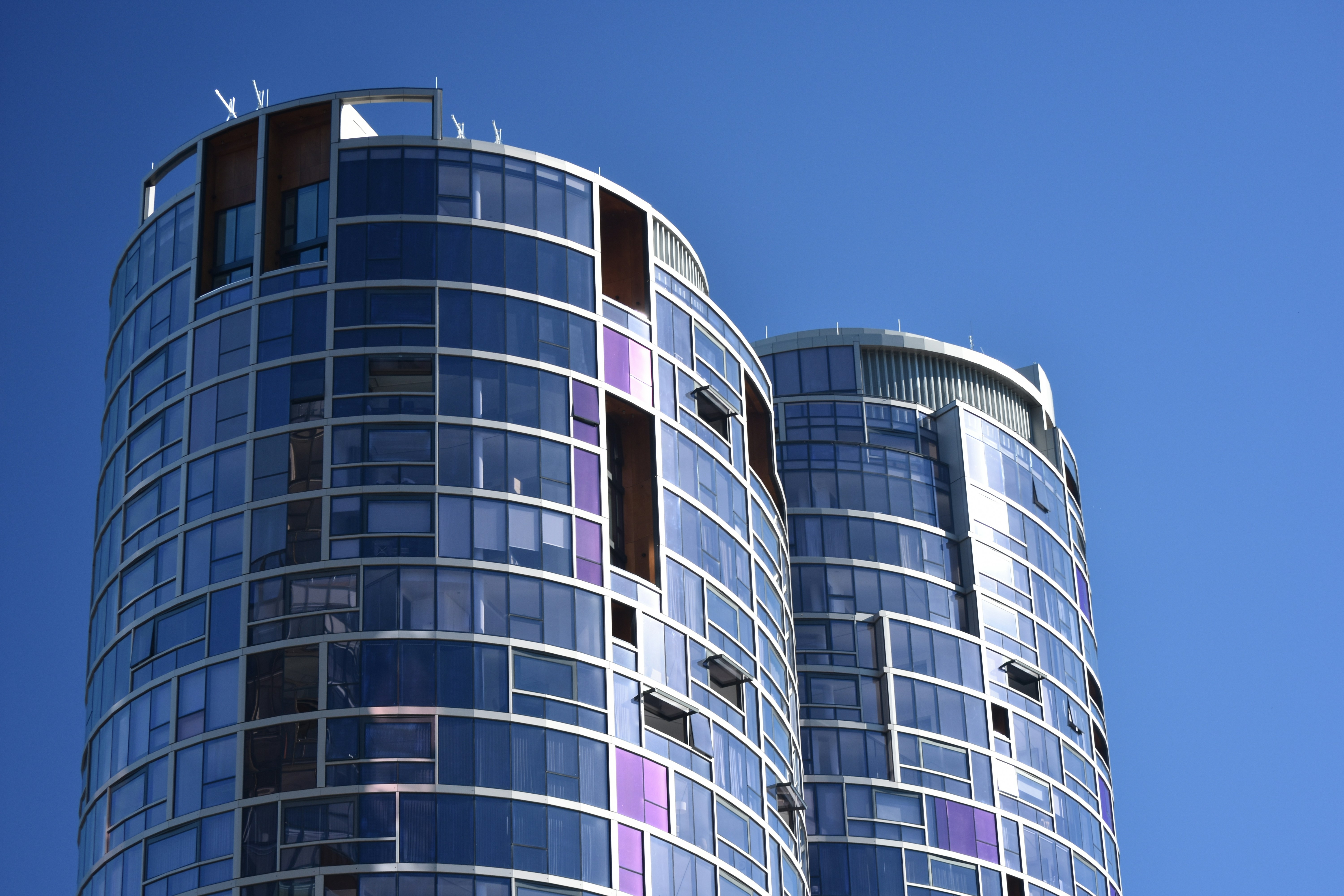 Azure Cylinders: Glass Facades Arching into a Clear Blue Sky