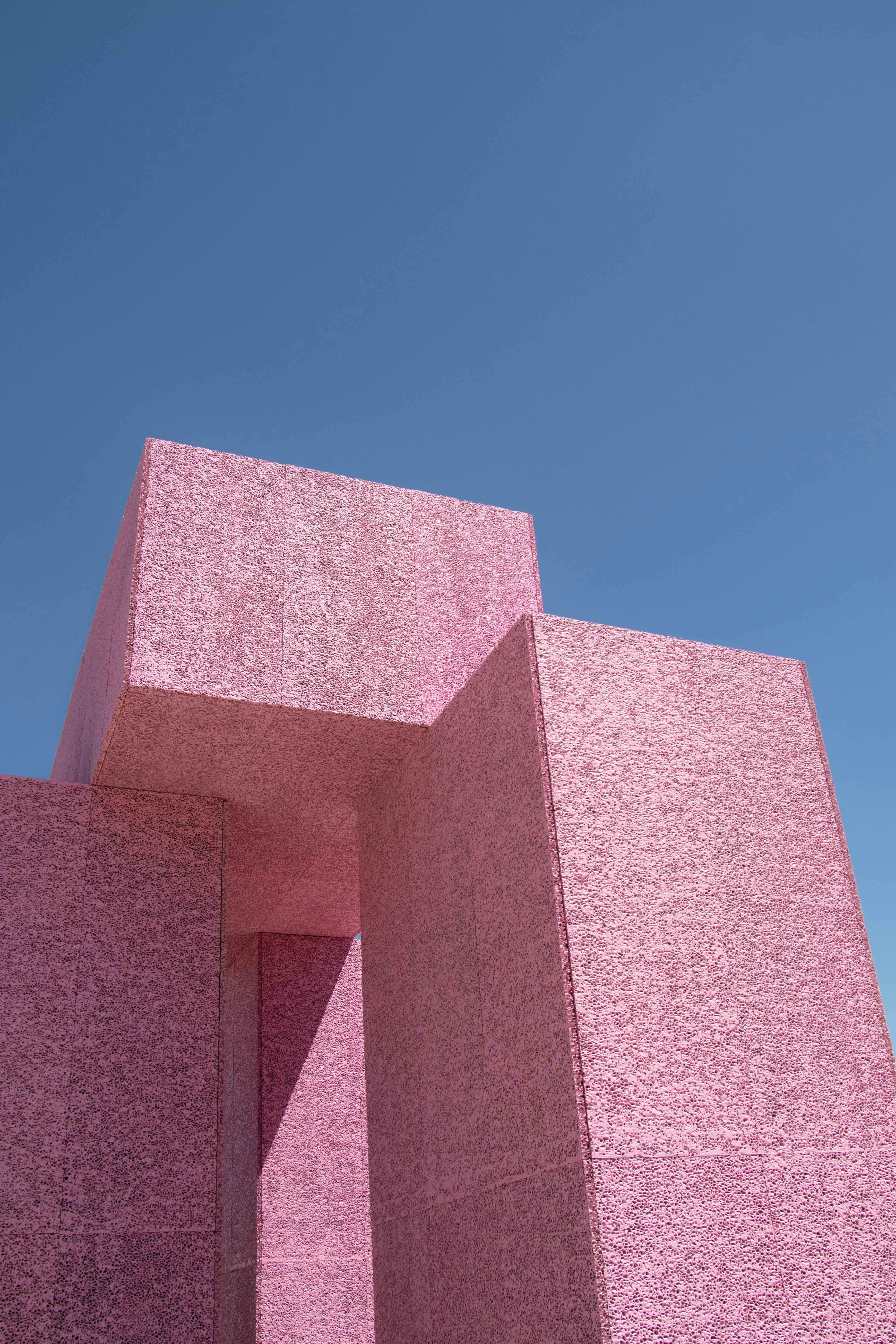 Interlocking Pink Monoliths Reach into a Cerulean Sky