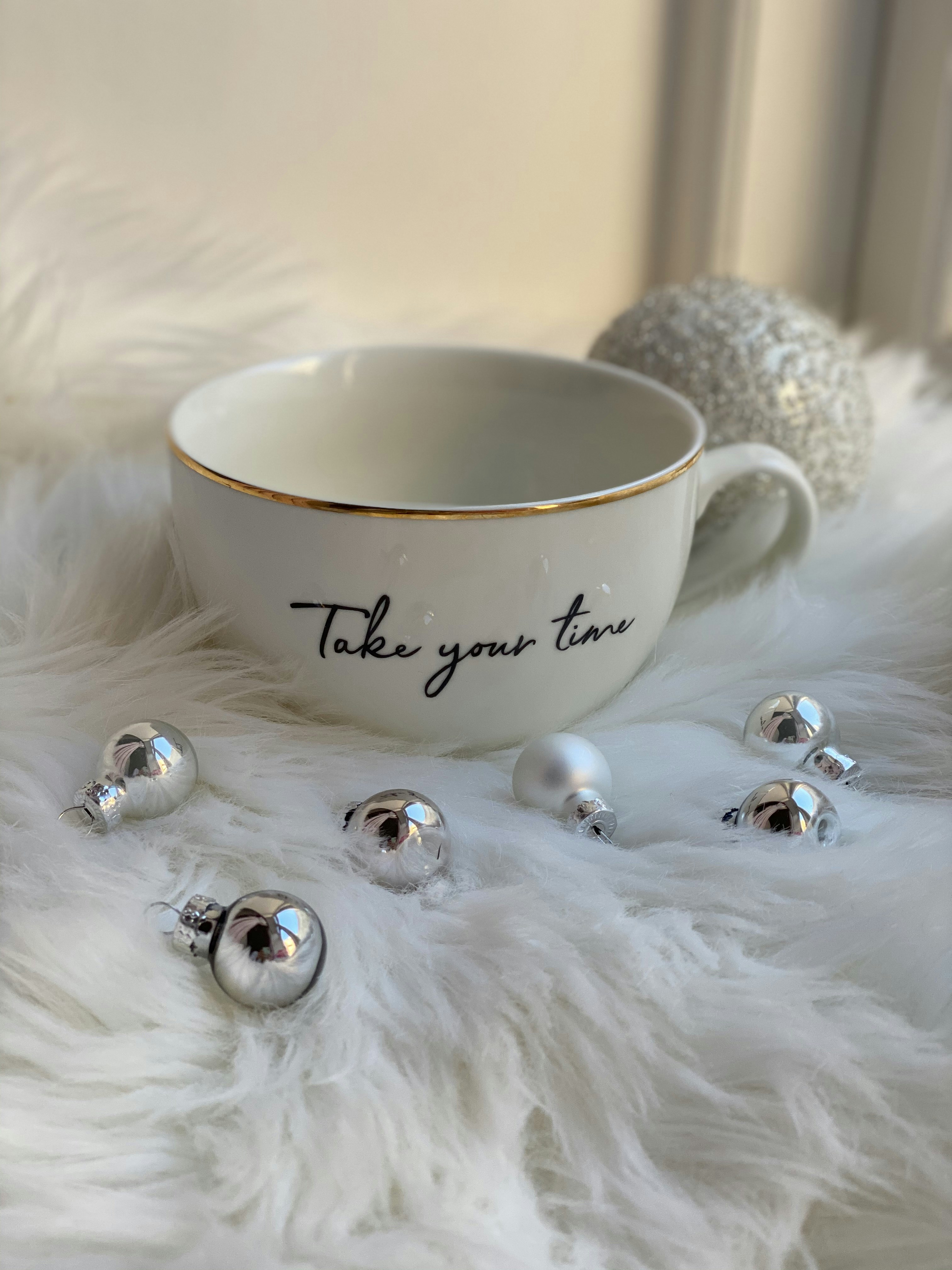 Ceramic Cup with 'Take your time' Surrounded by Silvery Orbs on Plush Snow