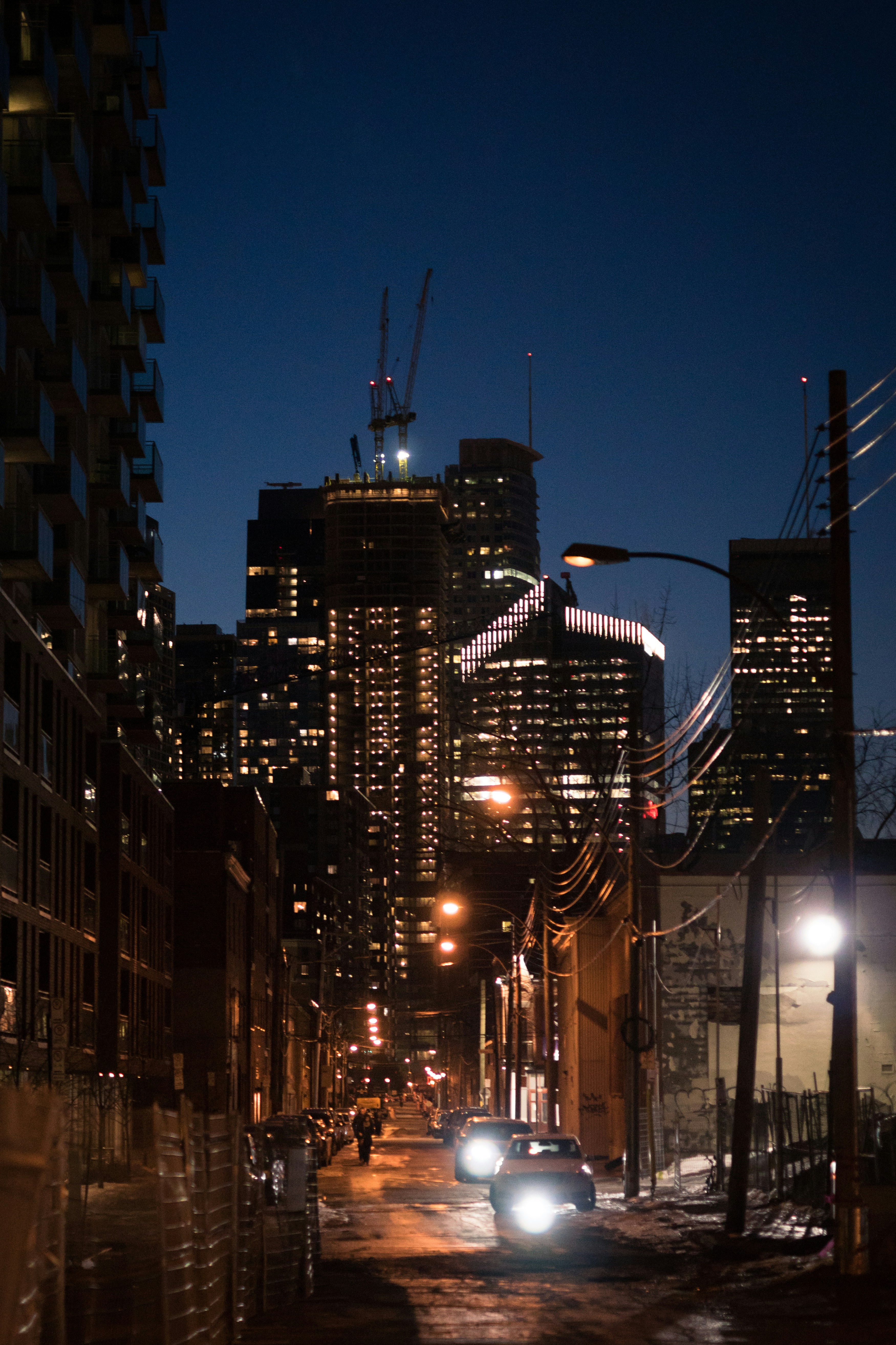 Cranes Over Neon Night: Snow-Kissed Downtown Skyline