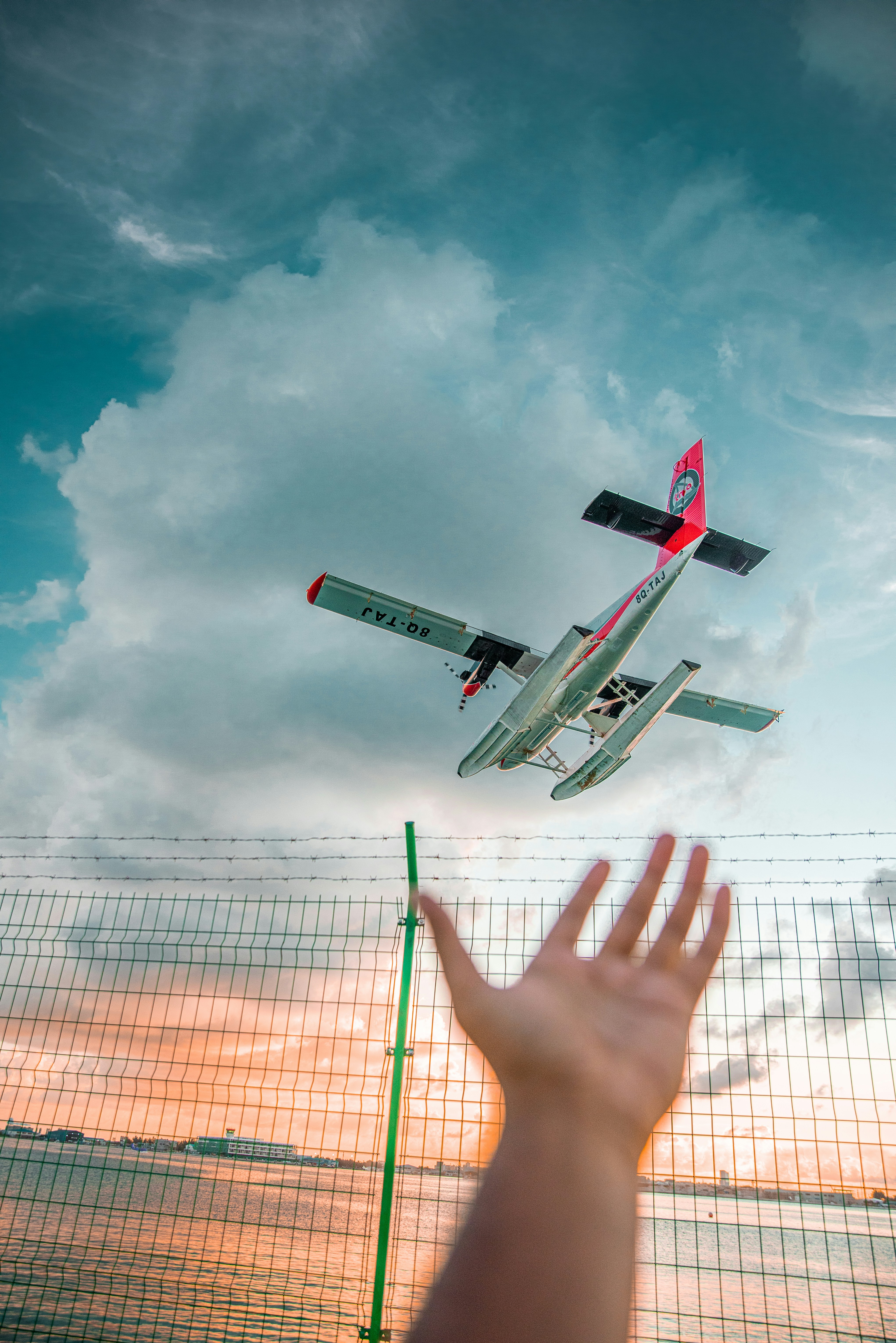 Red-Tailed Seaplane in a Low Pass Over a Fence