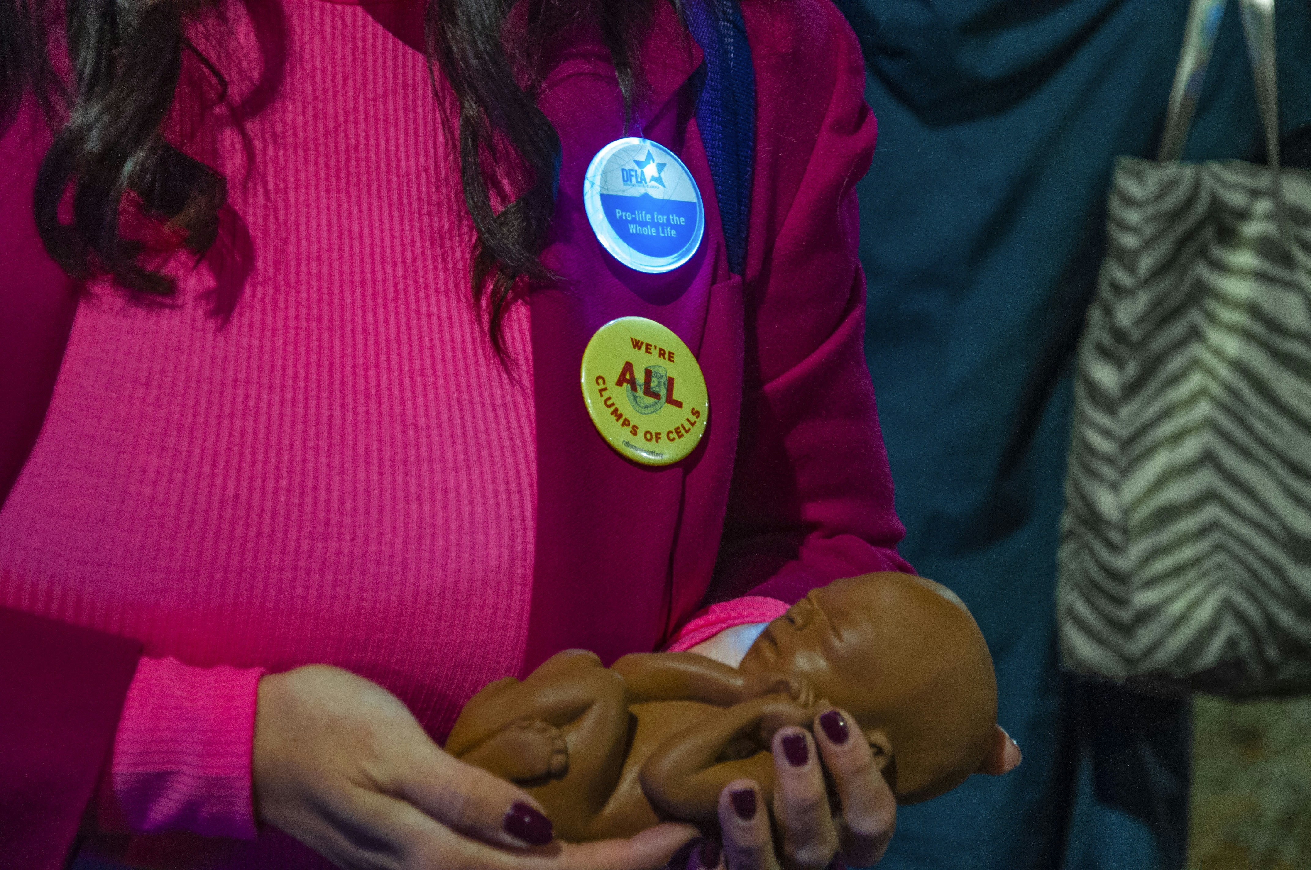 Cradling a Lifelike Baby Doll: A Quiet Gesture in Bright Pink