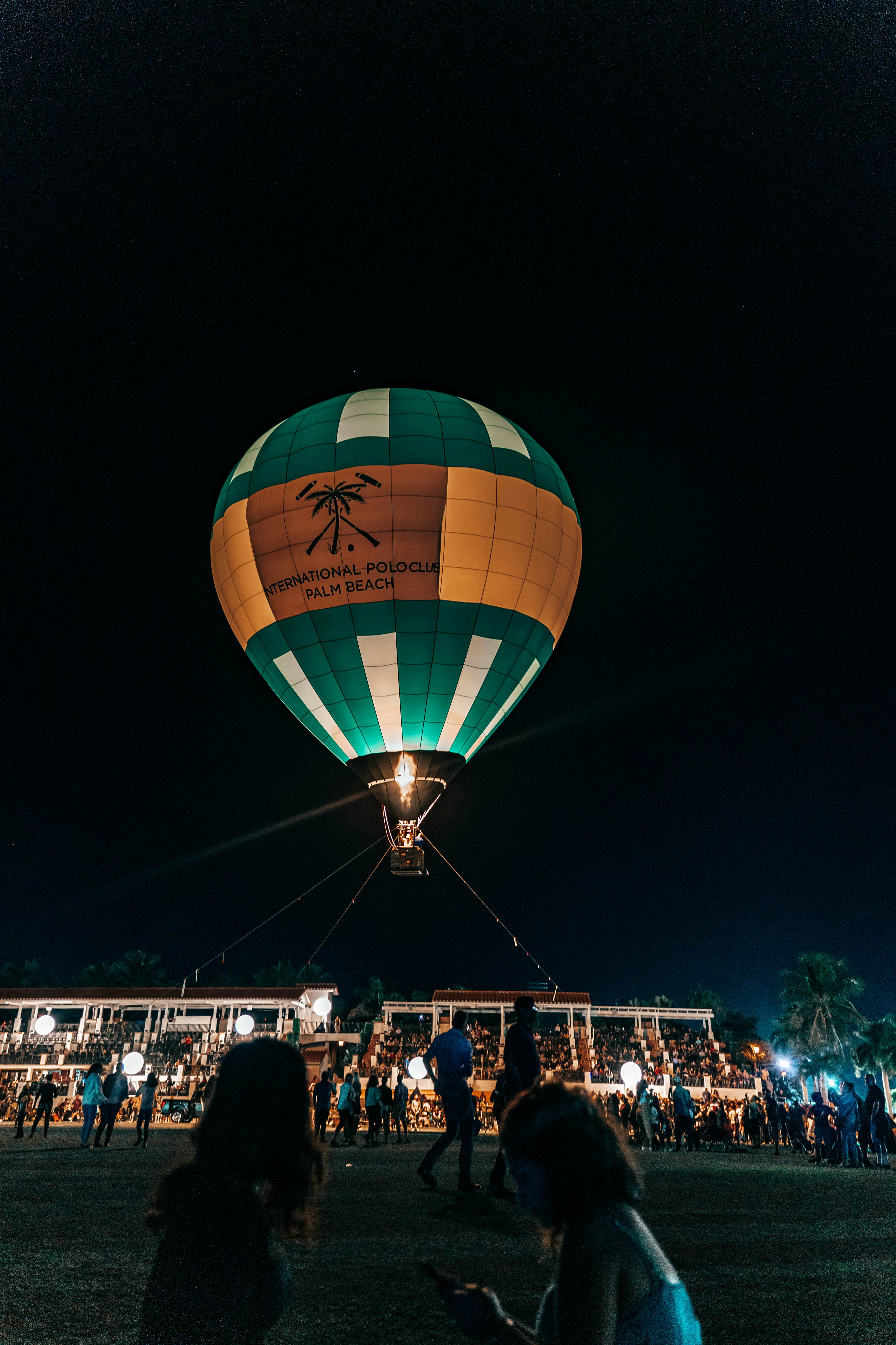 Teal and Amber Balloon Ascends Over a Lantern-Lit Night Crowd