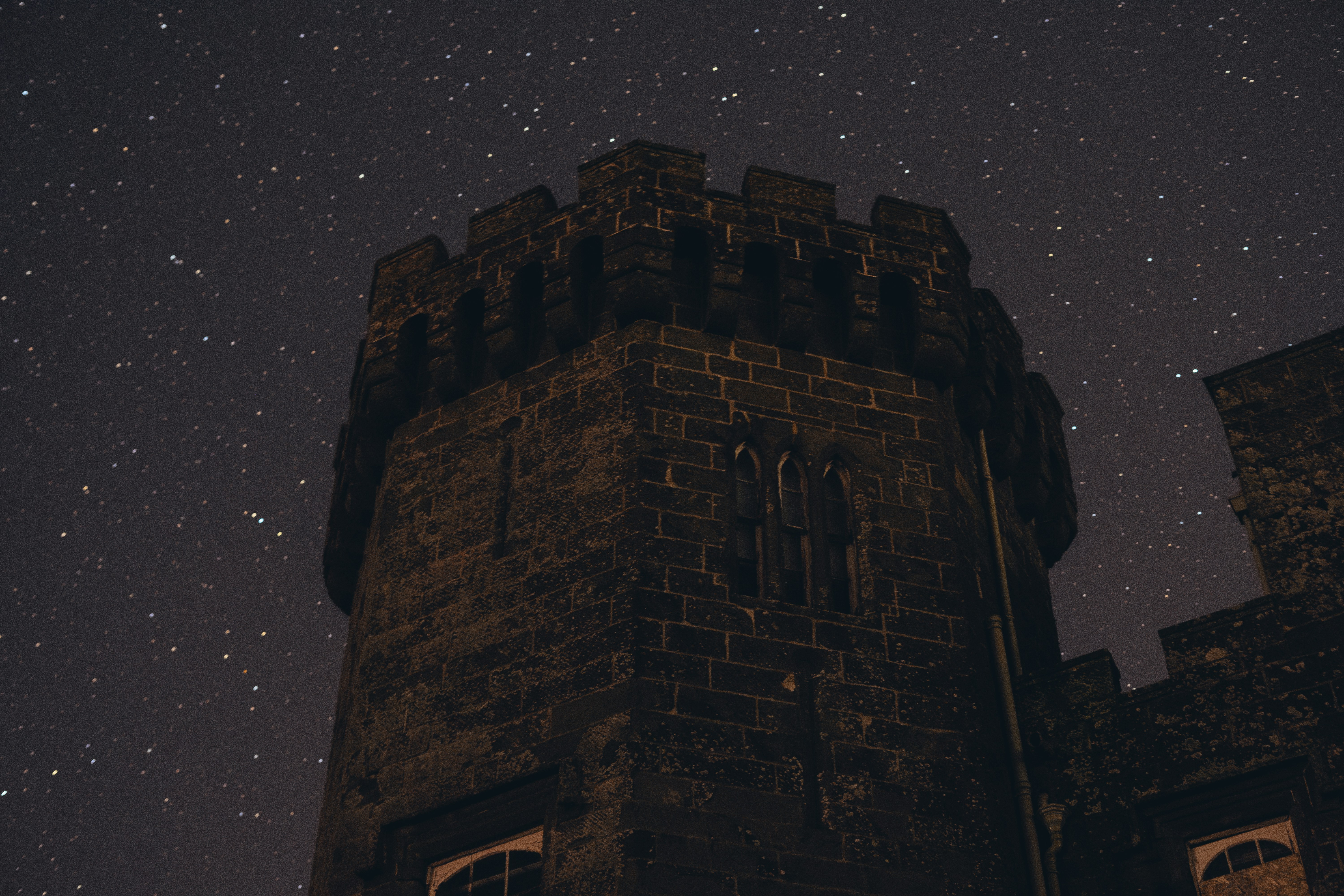 Stone castle tower silhouetted against a starry night sky.