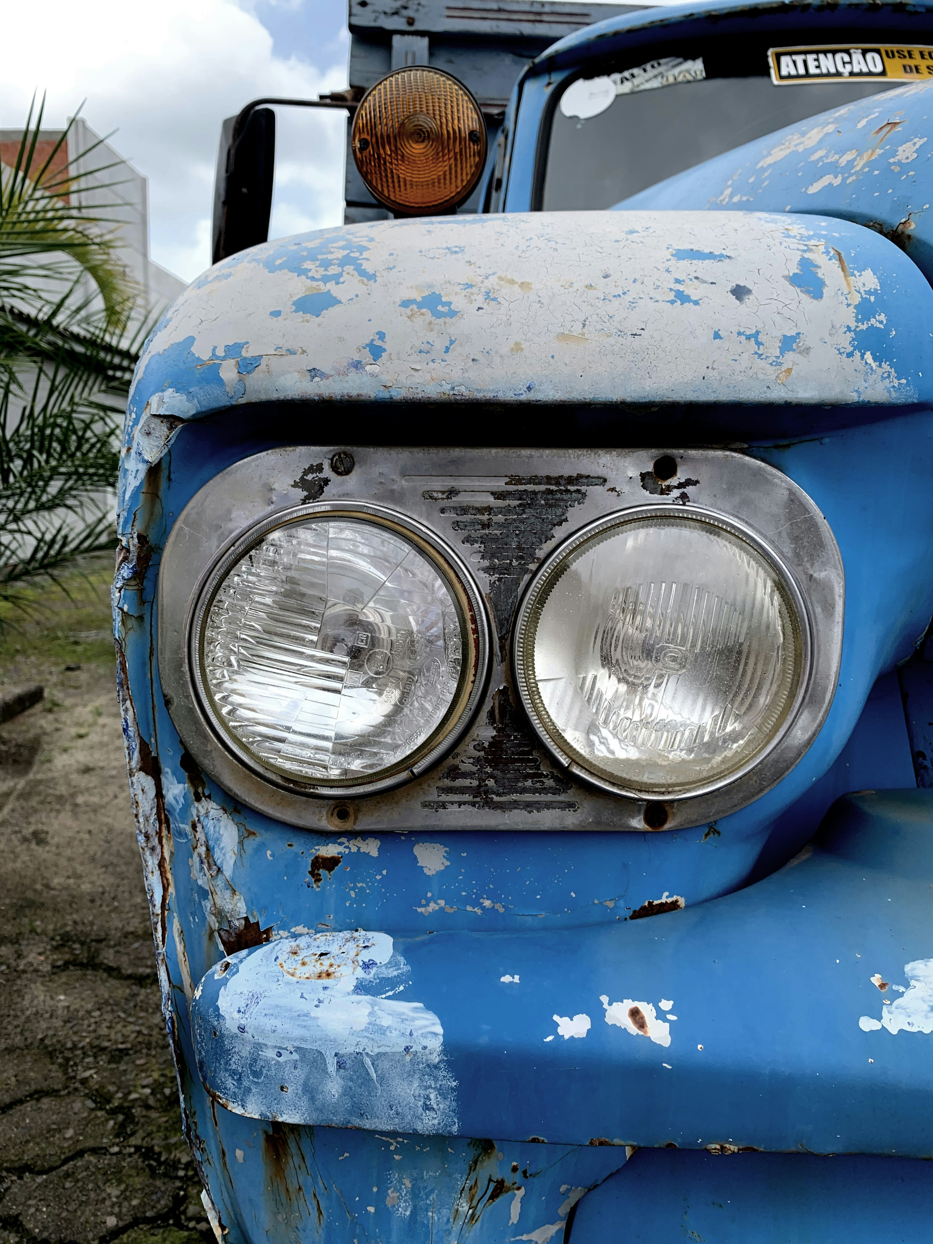 Weathered Blue Behemoth: Close-up of chipped enamel and twin headlights
